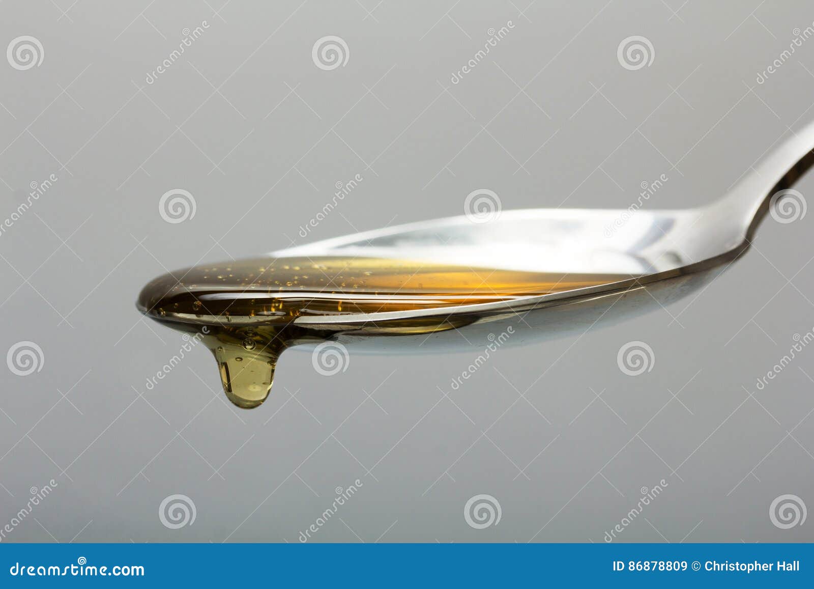 Honey Pouring from Spoon Against a Light Background Stock Image - Image ...