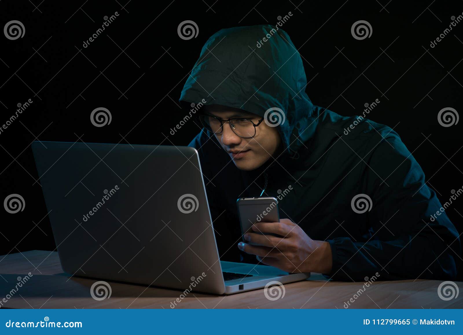 Hooded Cyber Crime Hacker Using Mobile Phone Internet Hacking in Stock ...