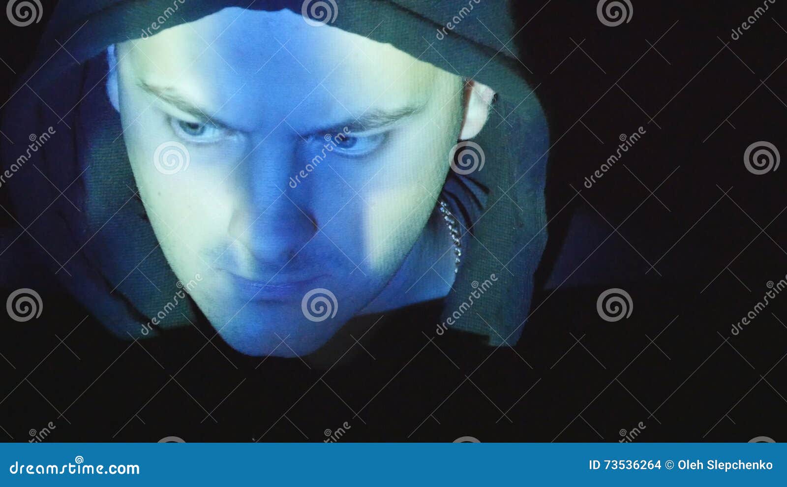 Hooded Hacker Working on a Computer, Binary Code Projecting on His Face. Source Code Projected ...