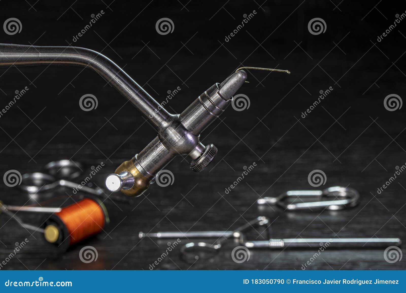 Hook and Fly Tying Tools on a Vise on a Black Background Hook and Fly ...