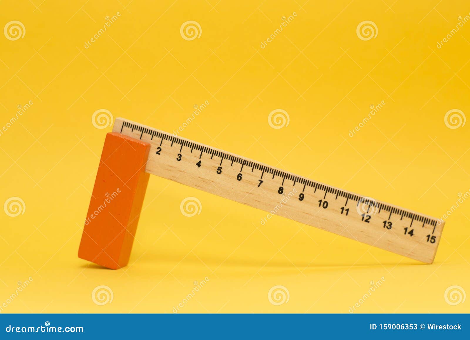 Horizontal Shot of a Brown Ruler with an Orange Stand on a Yellow ...