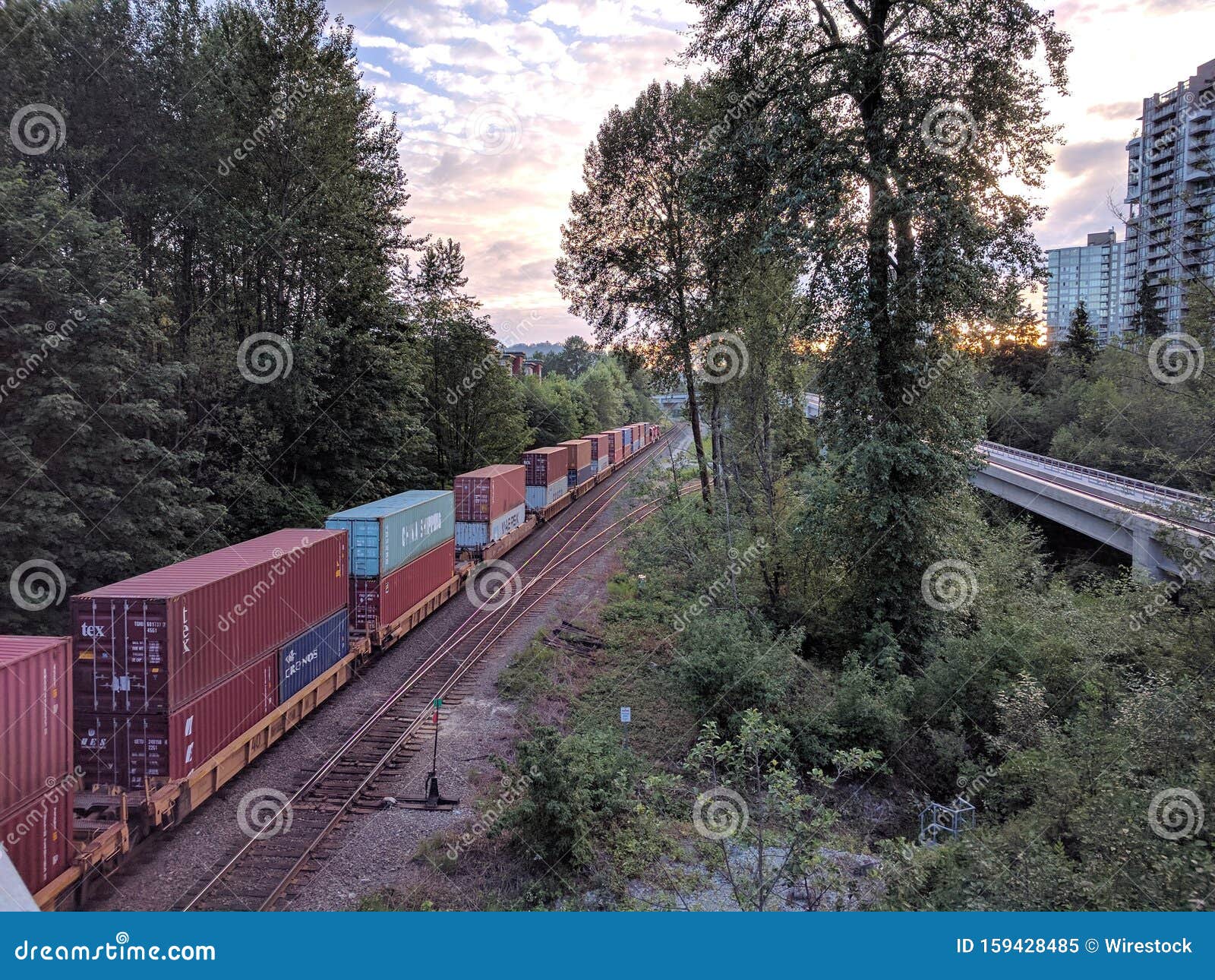 Horizontal Shot of a Cargo Train Loaded with Containers Riding Towards ...
