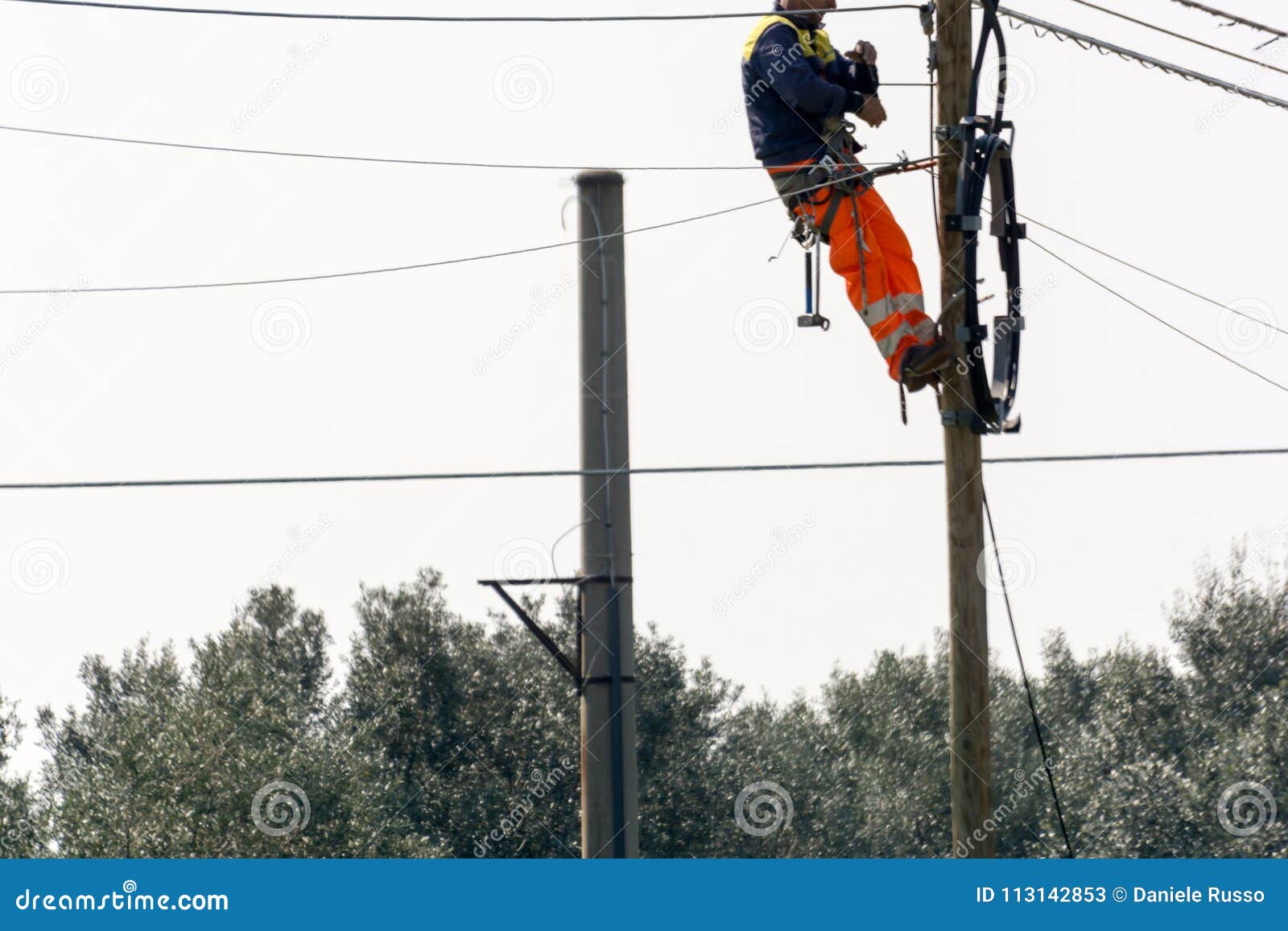 Horizontal View of a Worker Repairing a Light Pole with Safety T ...