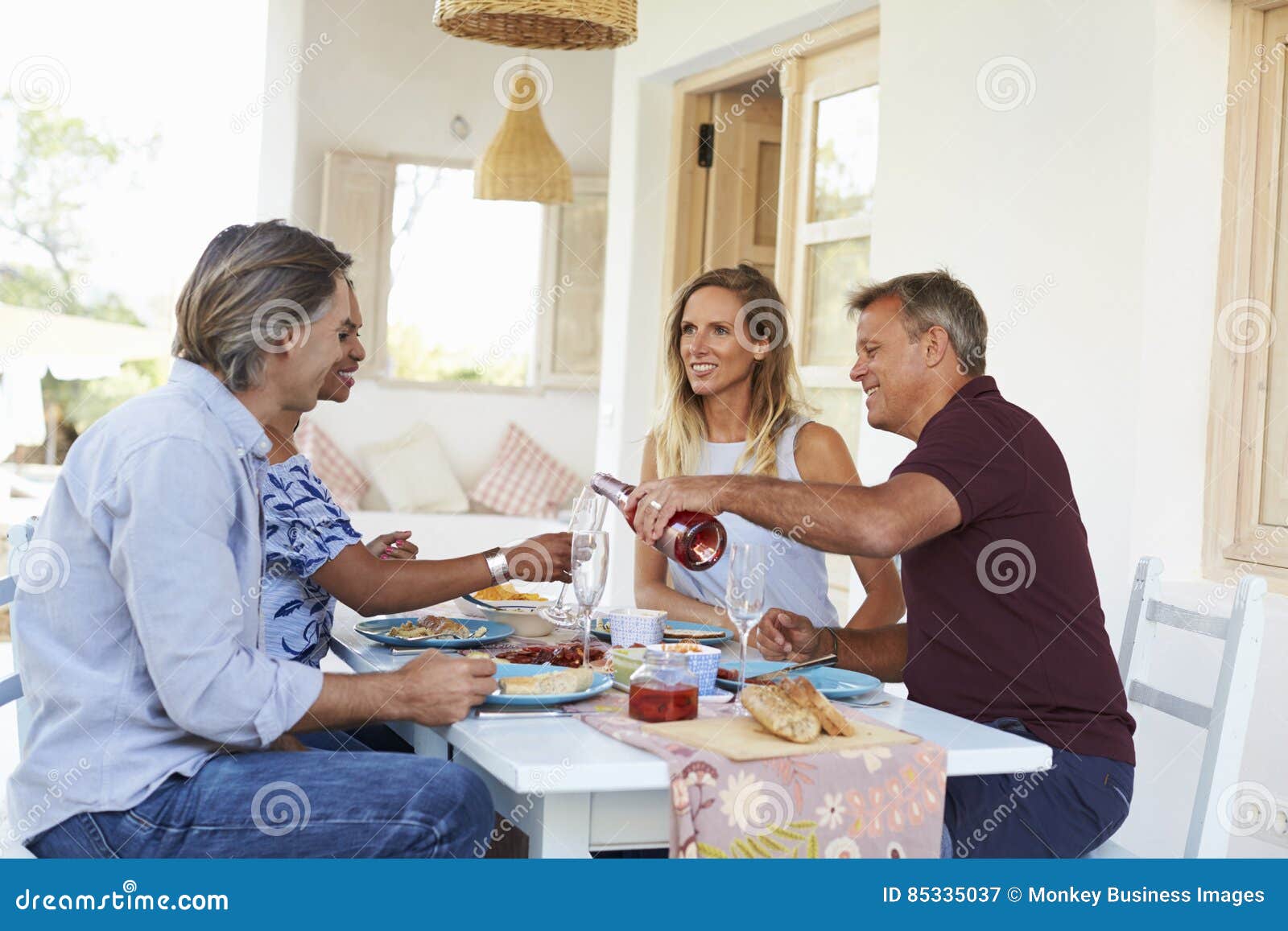 Host Pouring Wine for Dinner Guests at a Table on a Patio Stock Image ...