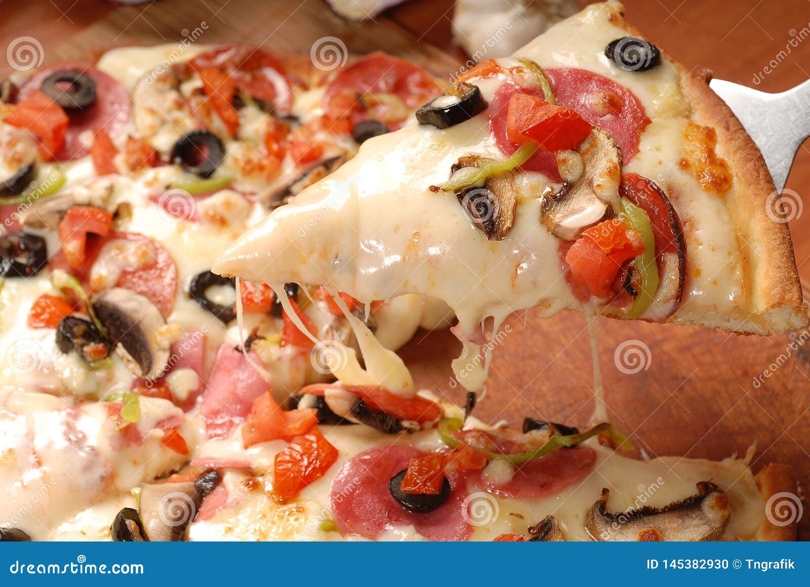 Hot Pizza Slice with Melting Cheese on a Rustic Wooden Table Stock ...