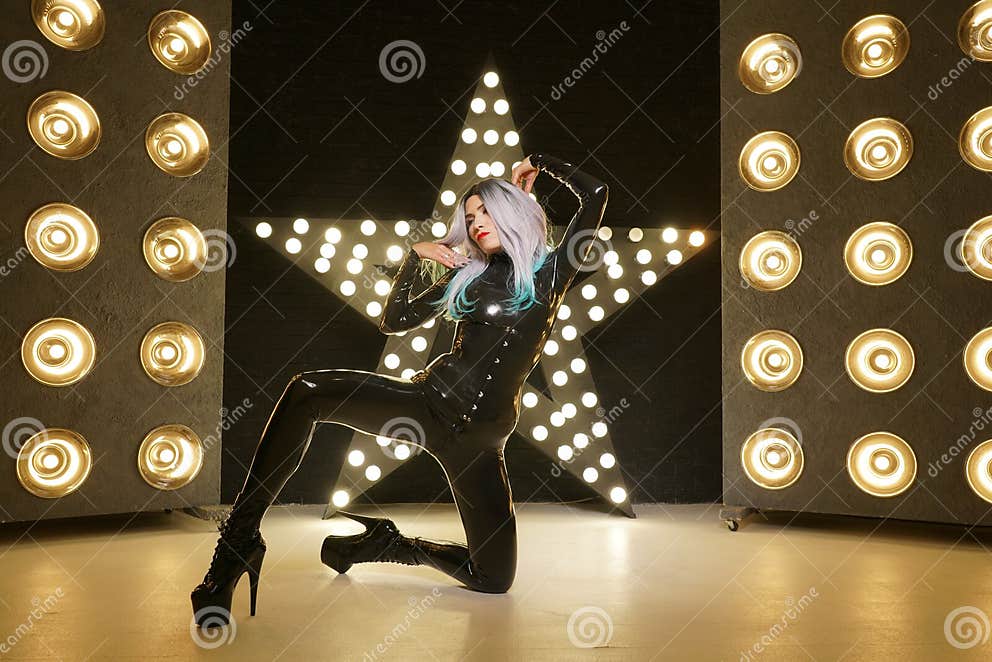 Hot Slim Woman Posing In Latex Rubber Fashion Clothes On Black