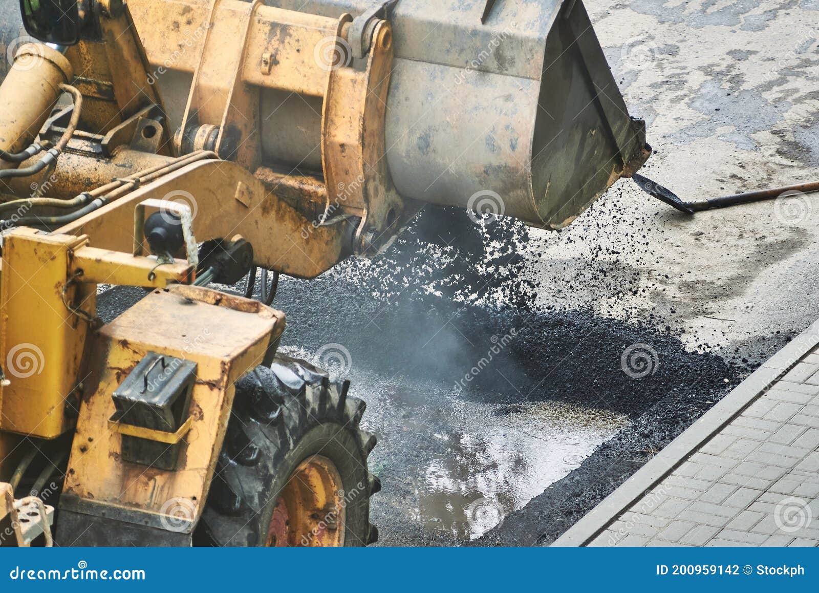 Hot Smoking Asphalt Excavator Ejects from the Bucket. Paving with a ...