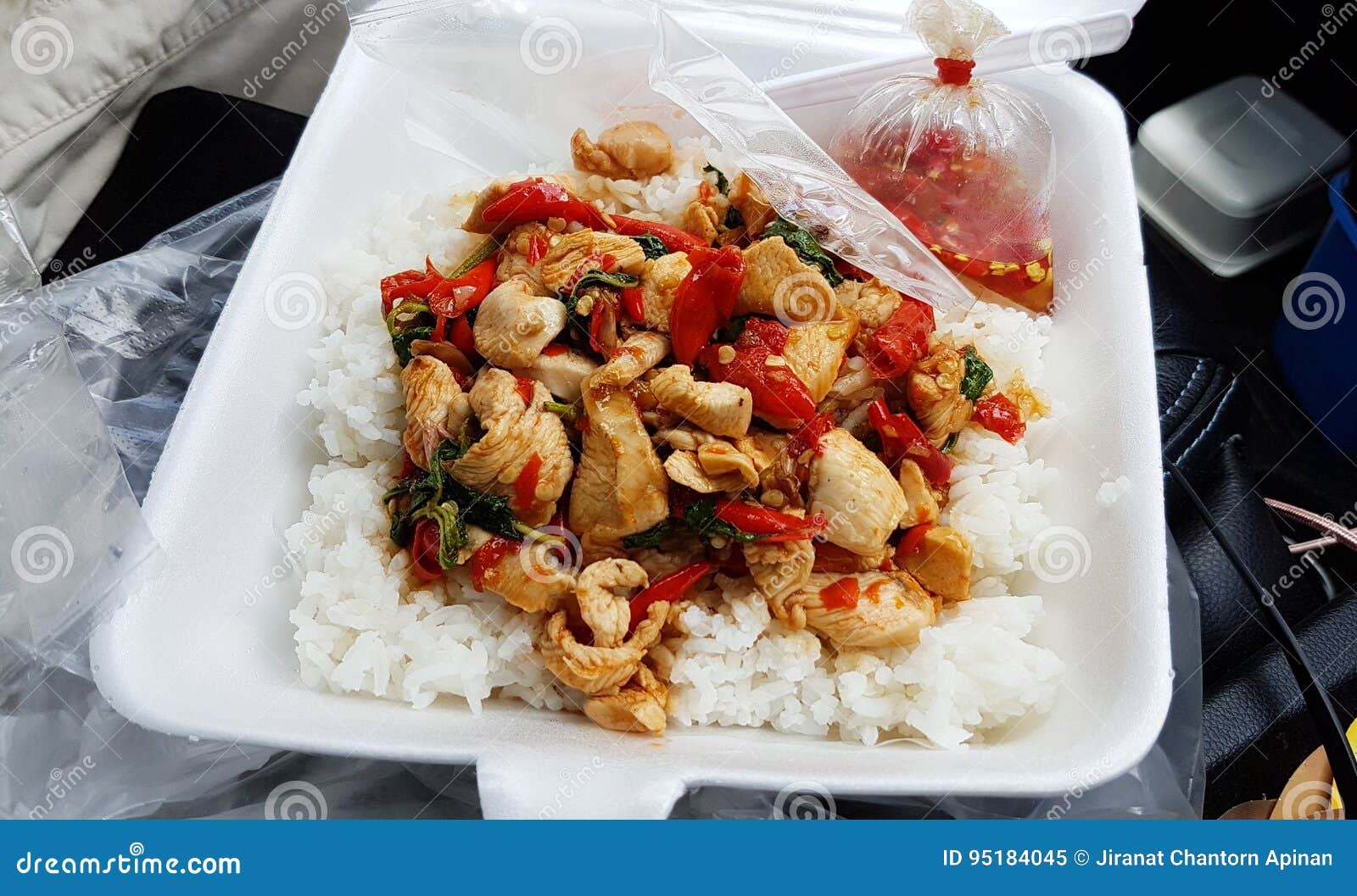 Spicy Basil Chicken With Fried Egg On Steamed Rice In Red Plastic Box ...