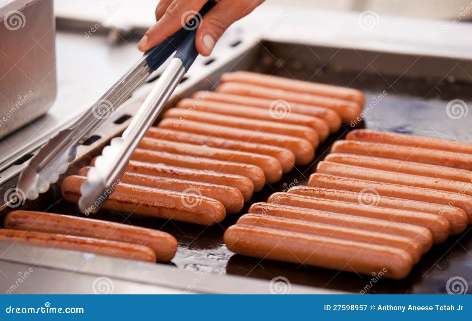 Hotdogs on a grill stock image. Image of food, hand, grill - 27598957