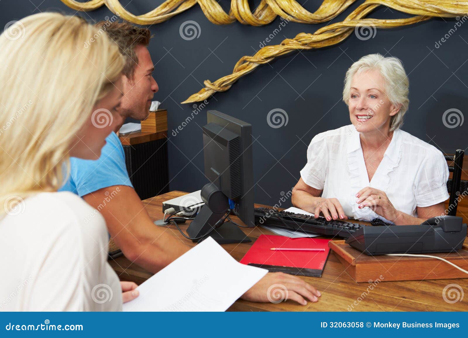 Hotel Receptionist Helping Couple To Check in Stock Photo - Image of ...