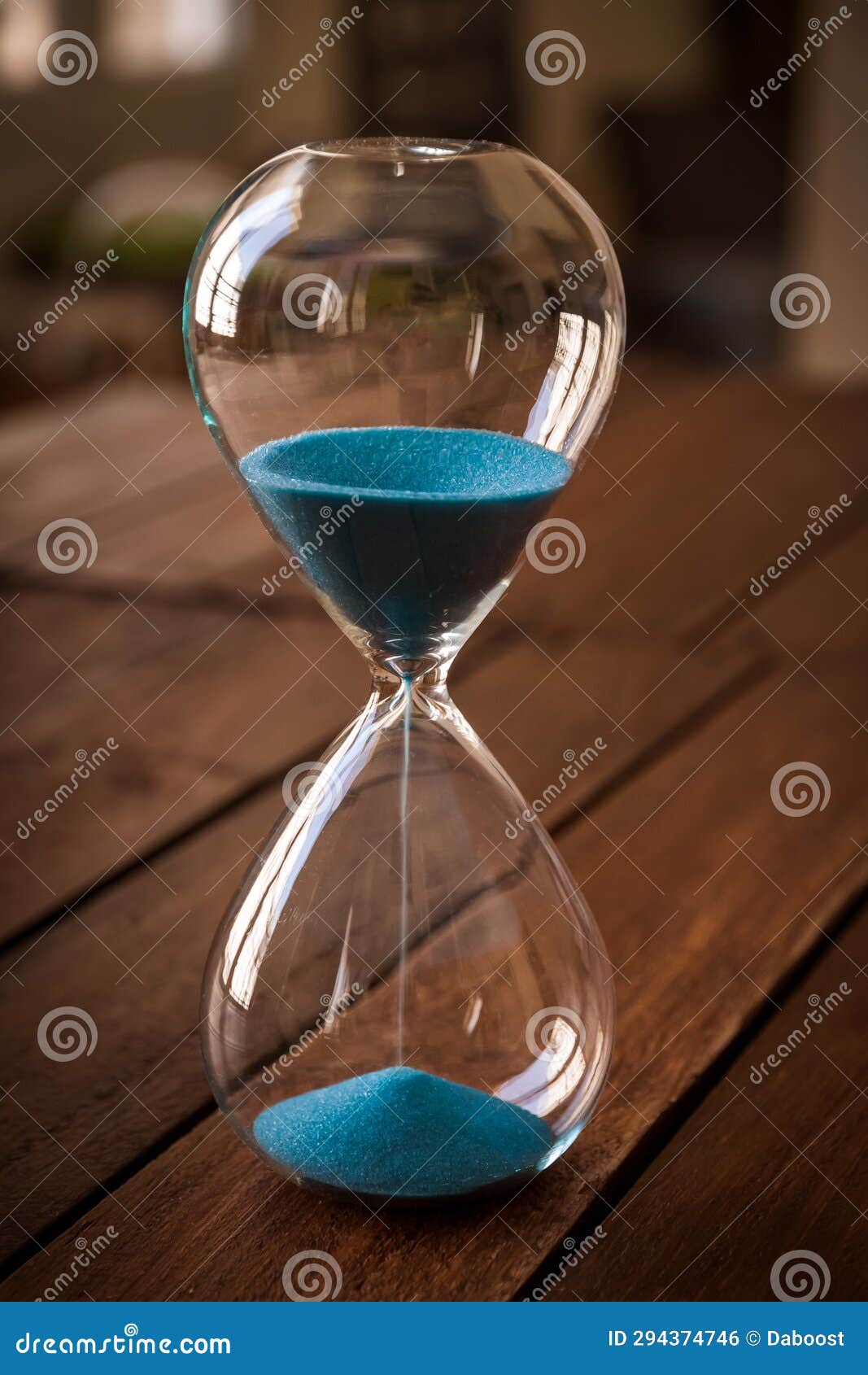 Hourglass Containing Blue Sand on a Rustic Wooden Board Stock Photo ...
