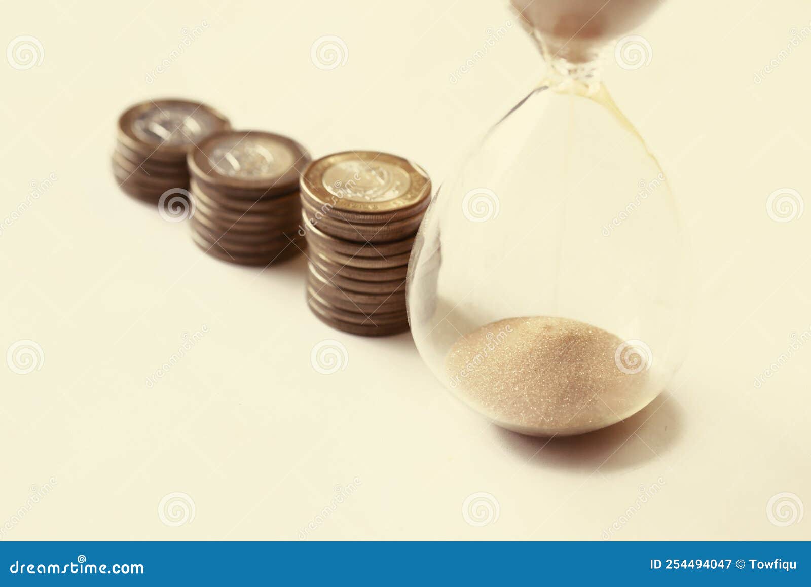 Hourglass and Stack of Coins on Table, Stock Image - Image of ...