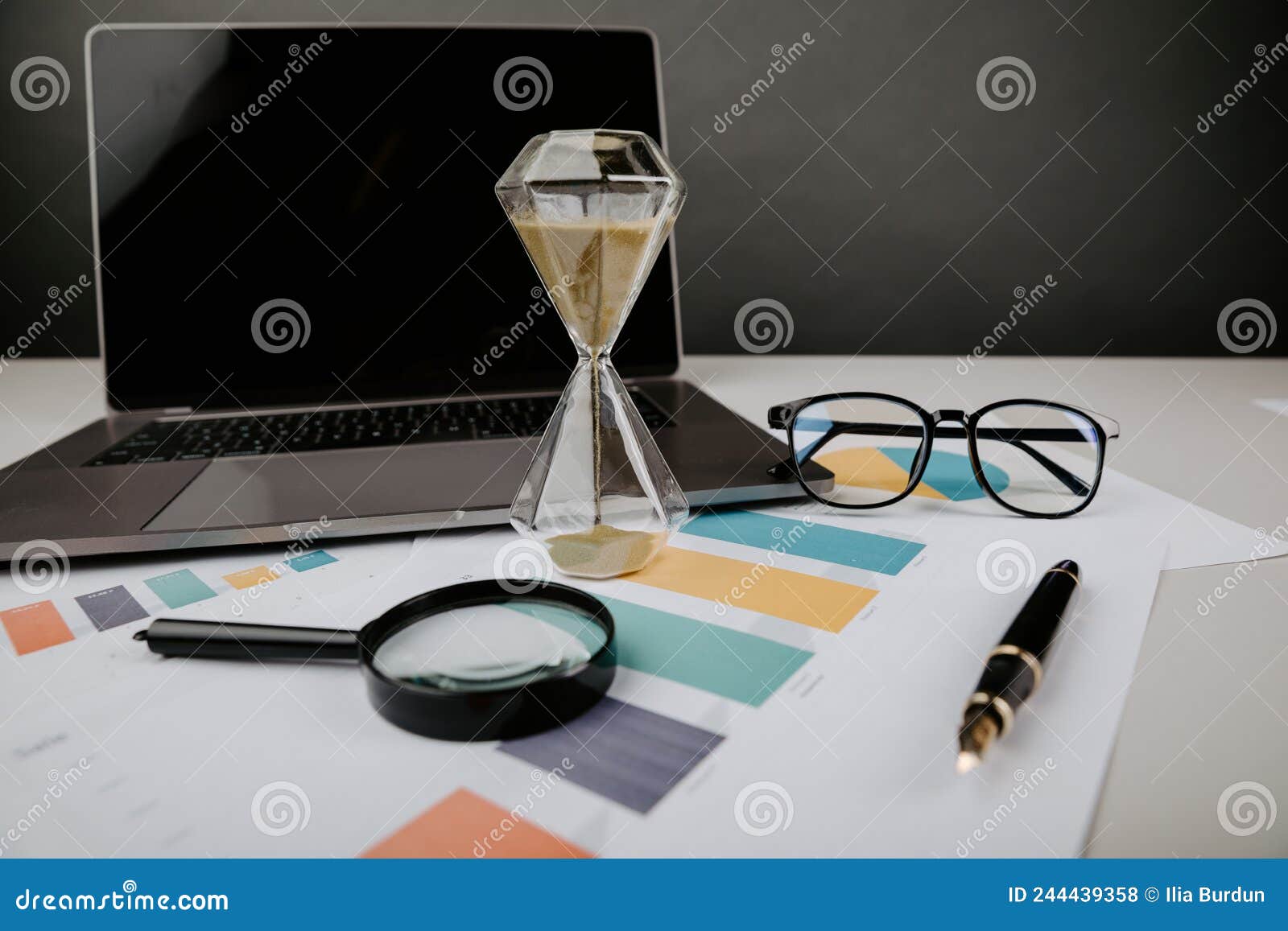 Hourglass on Working Table Whith Chart Paper and Laptop. Business ...