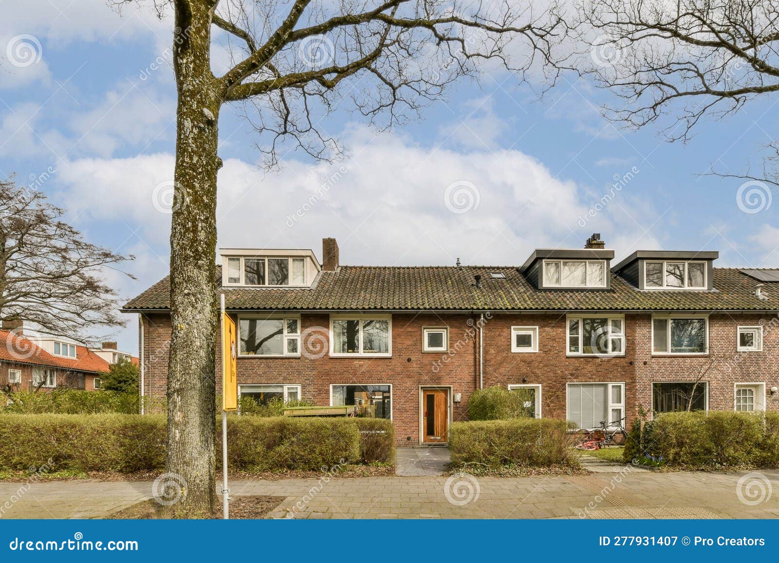 A Brick House with a Tree in Front of it Stock Image - Image of ...