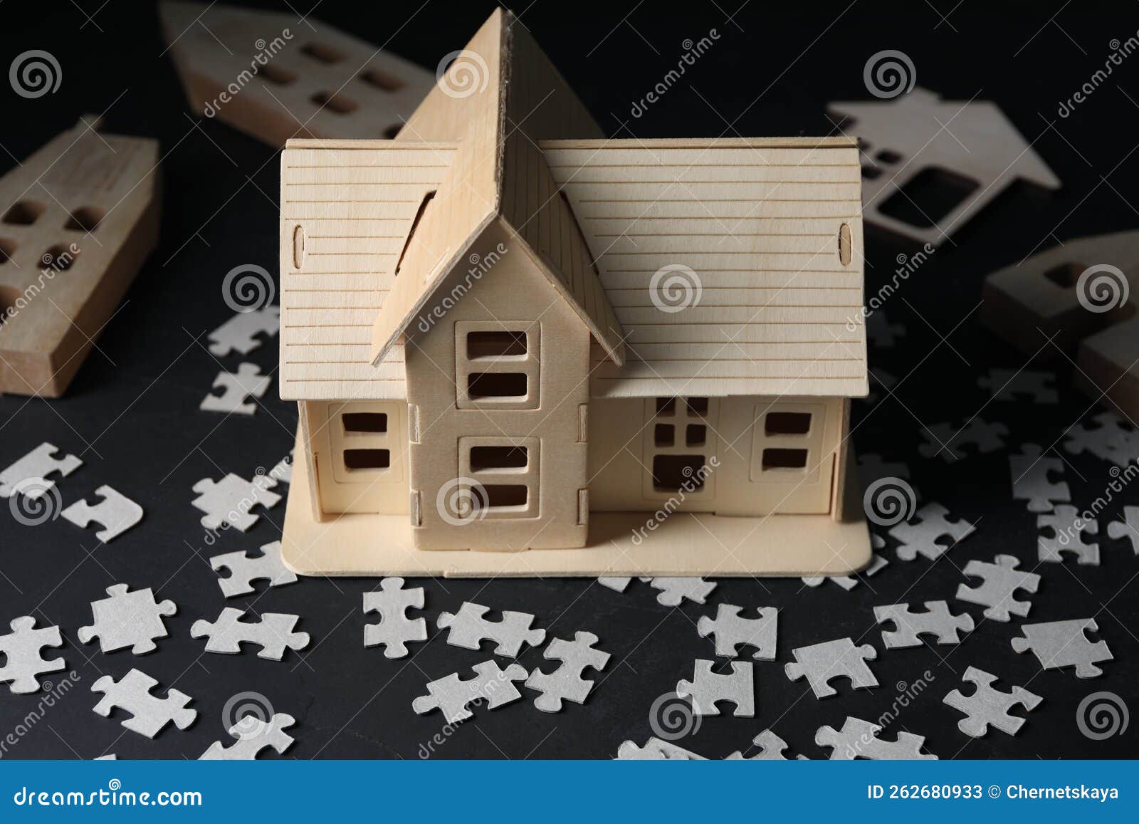 House Model and Puzzles on Black Table Depicting Destruction after ...