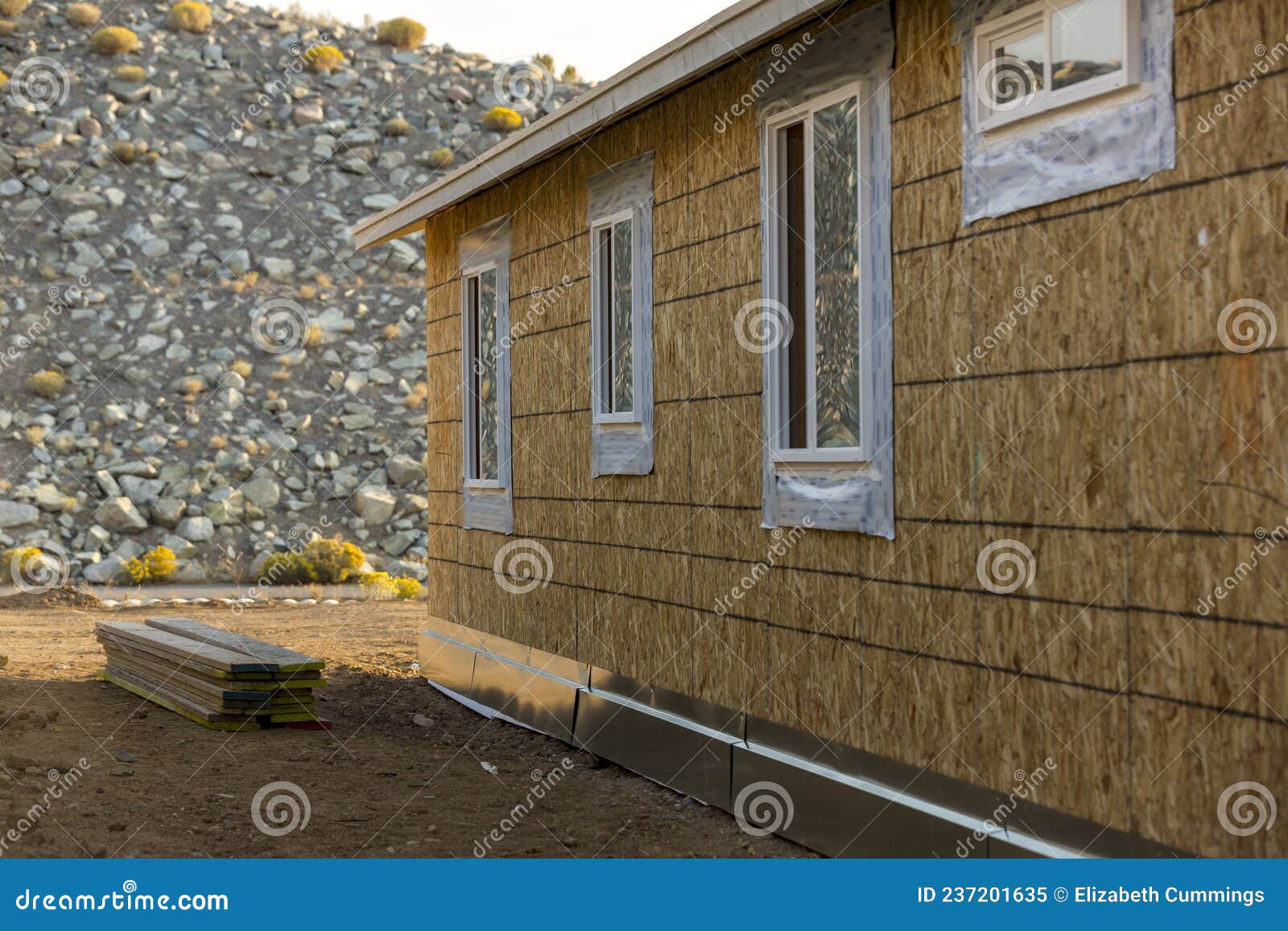 House Nearing Completion of Construction. Stack of Boards in the Dirt ...