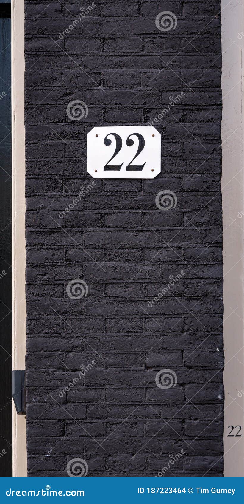 House Numbers Against a Black Brick Wall Background Stock Photo - Image ...