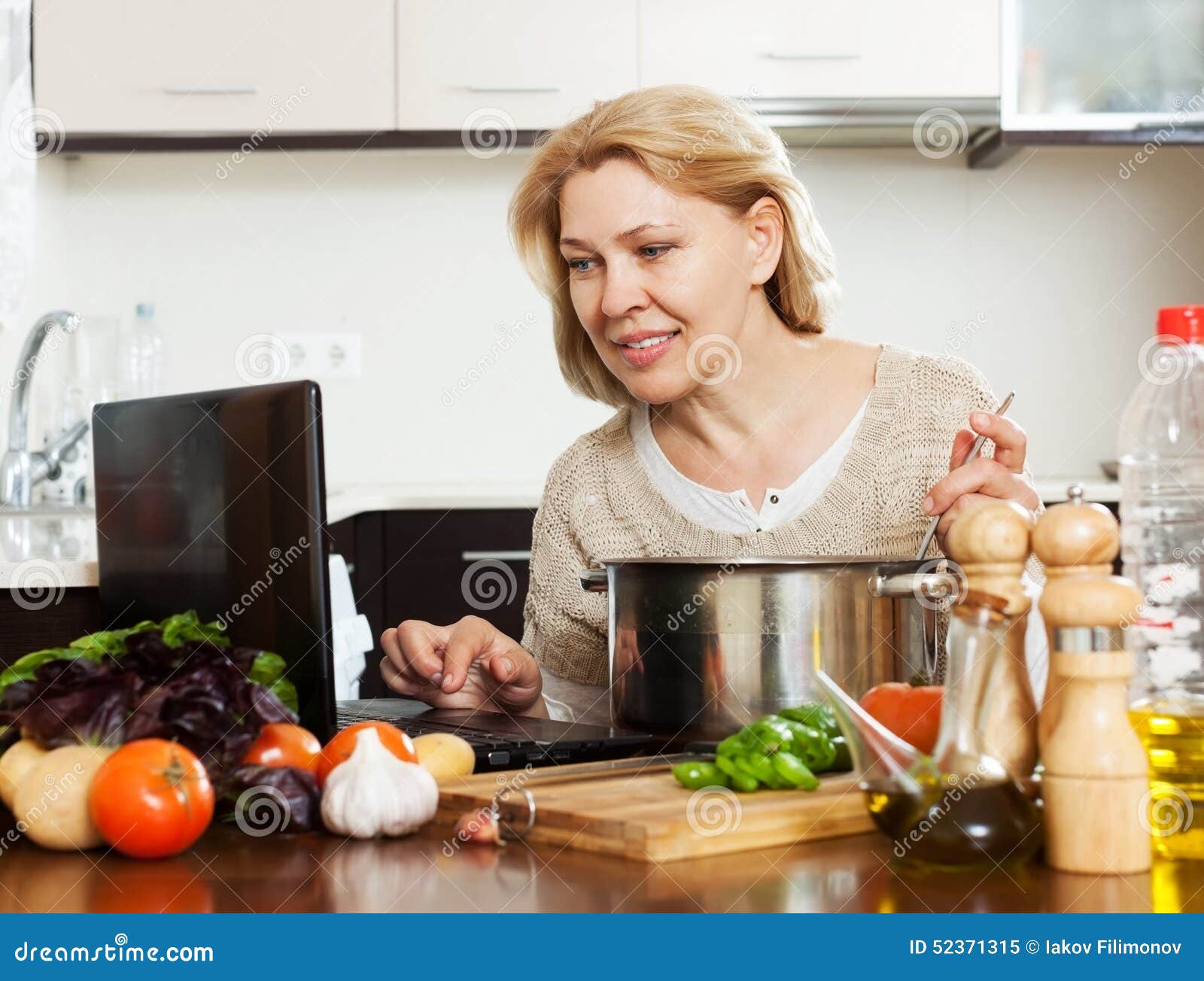Housewife Using Laptop while Cooking Stock Image - Image of looking ...