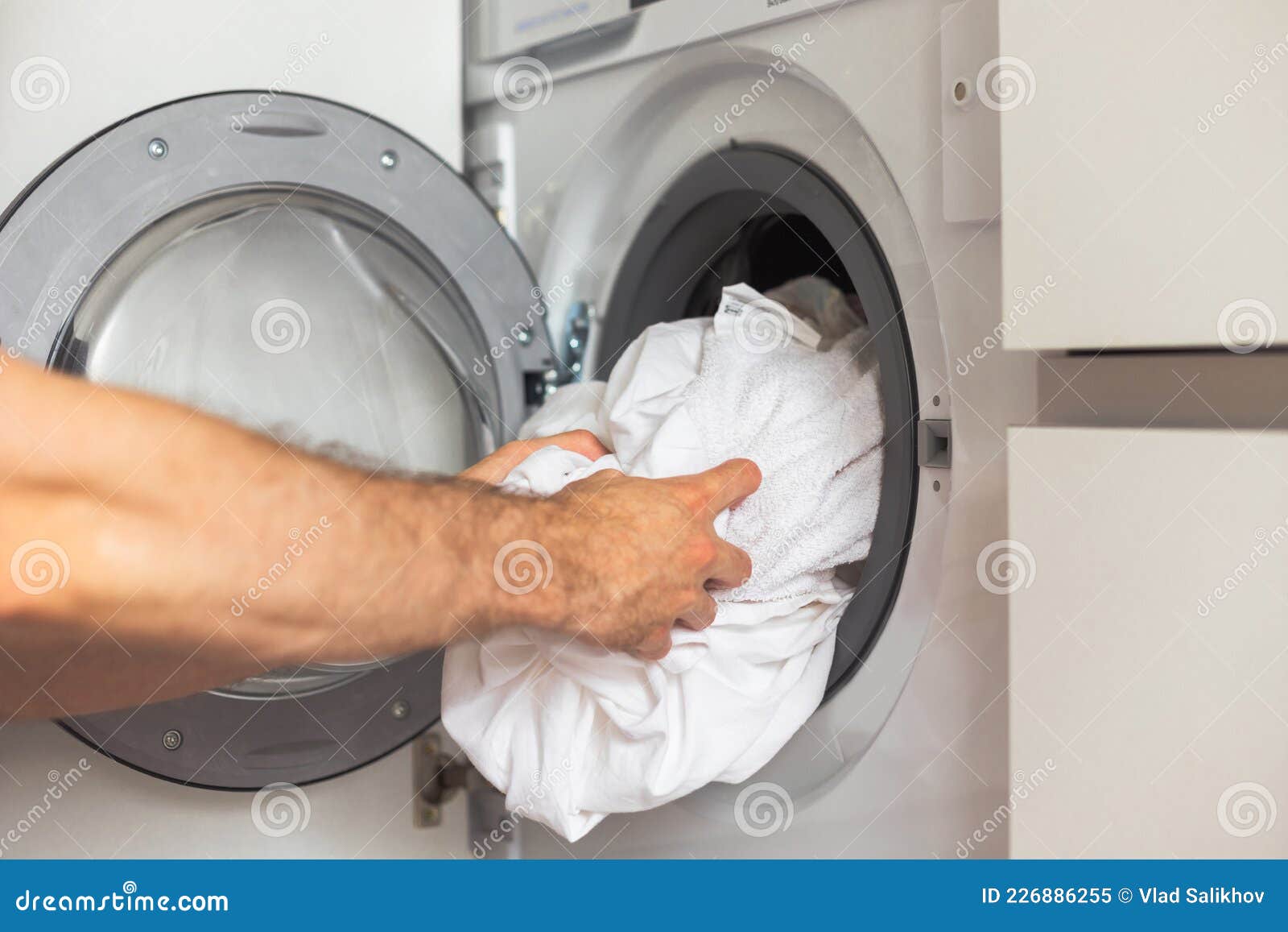 Housework: Man Loading Clothes into Washing Machine Stock Image - Image ...