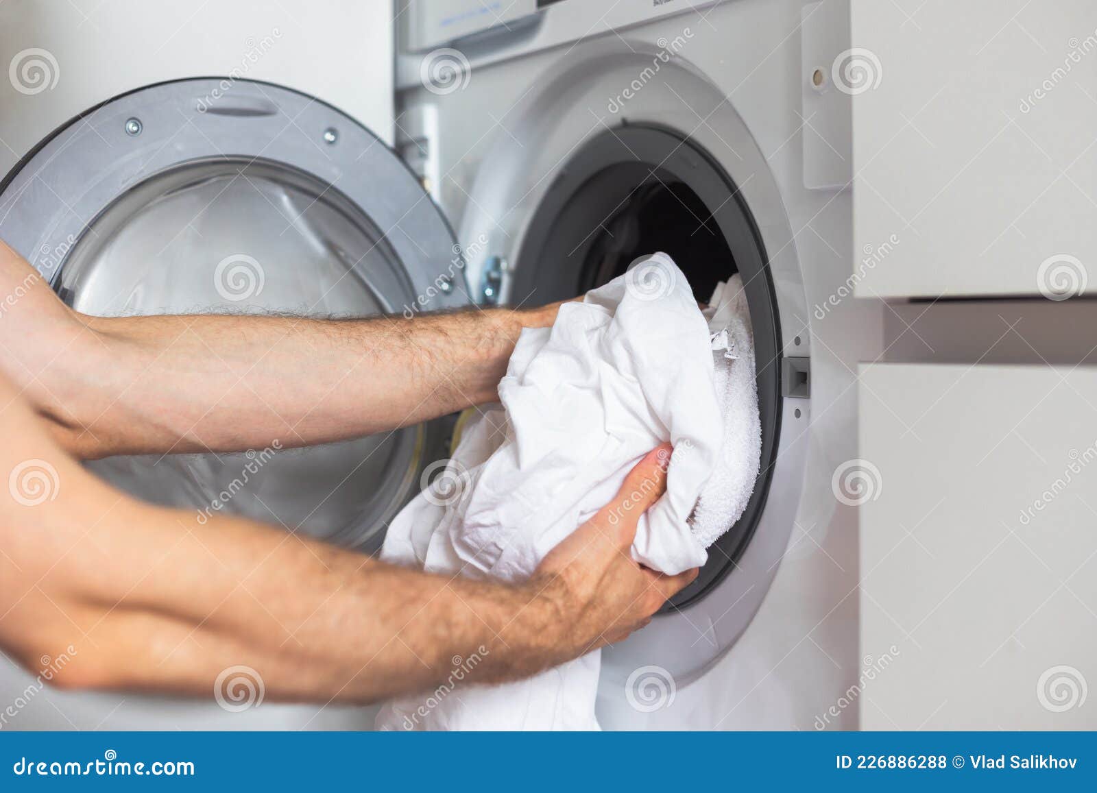 Housework: Man Loading Clothes into Washing Machine Stock Photo - Image ...