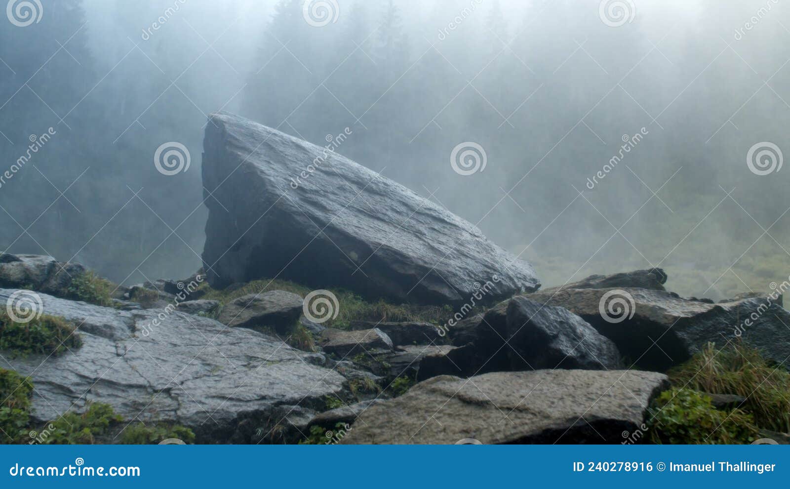 Huge Rock Next To Waterfall with Wind Pushing Water into the Air Stock ...