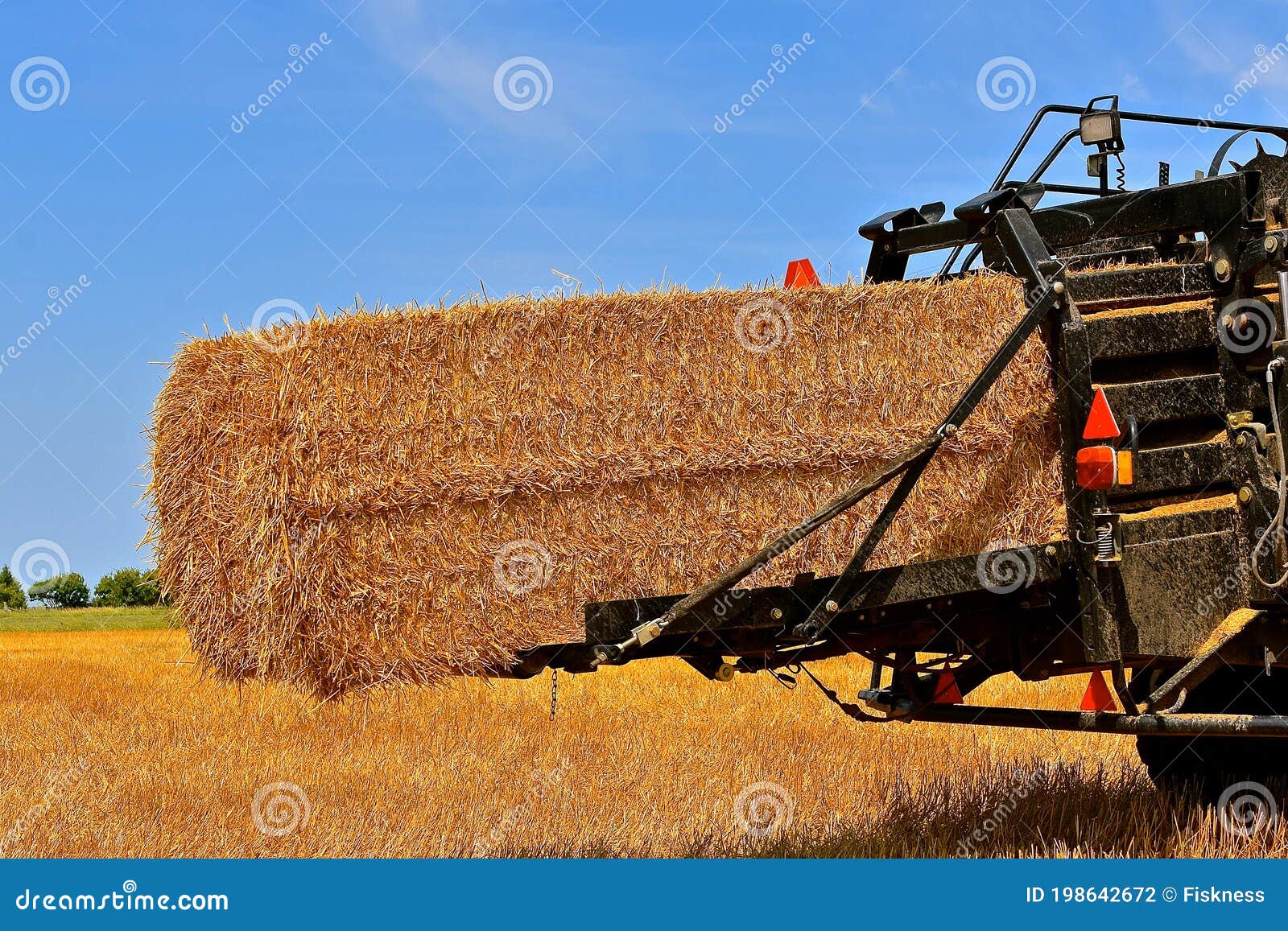A Huge Straw Bale Leaves The Baler Chute Stock Photo | CartoonDealer ...