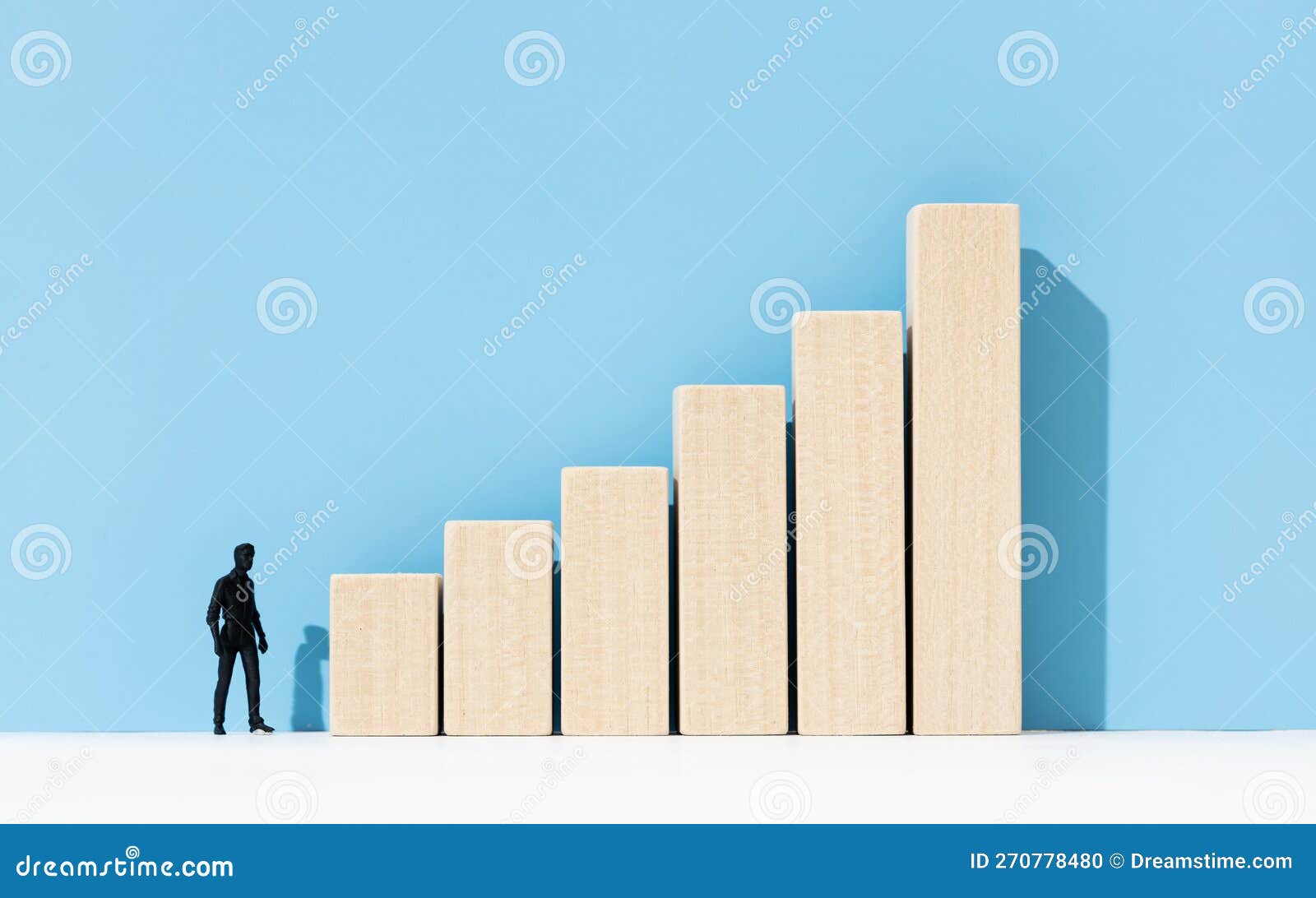 Human Figurine Looking at a Growing Bar Chart Stock Photo - Image of ...