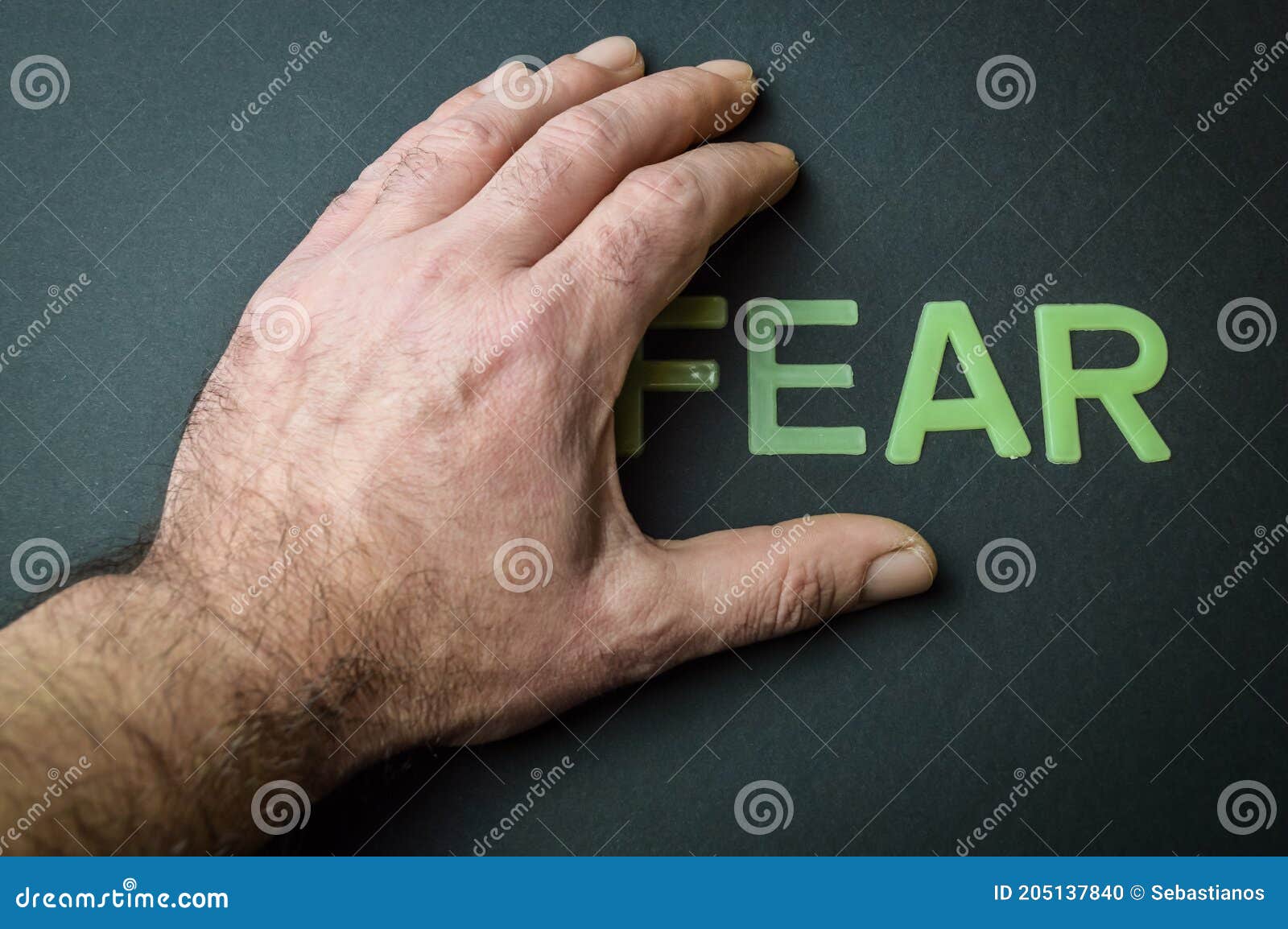 Human Hand Hides the Word Fear Written with Plastic Letters on Dark ... Human Hand Hides the Word Fear Written with Plastic Letters on Dark ...