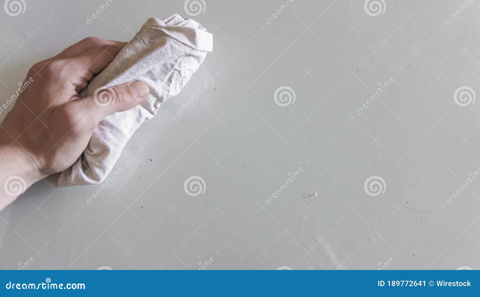 Human Hand Holding a White Piece of Fabric and Wiping the White Surface ...