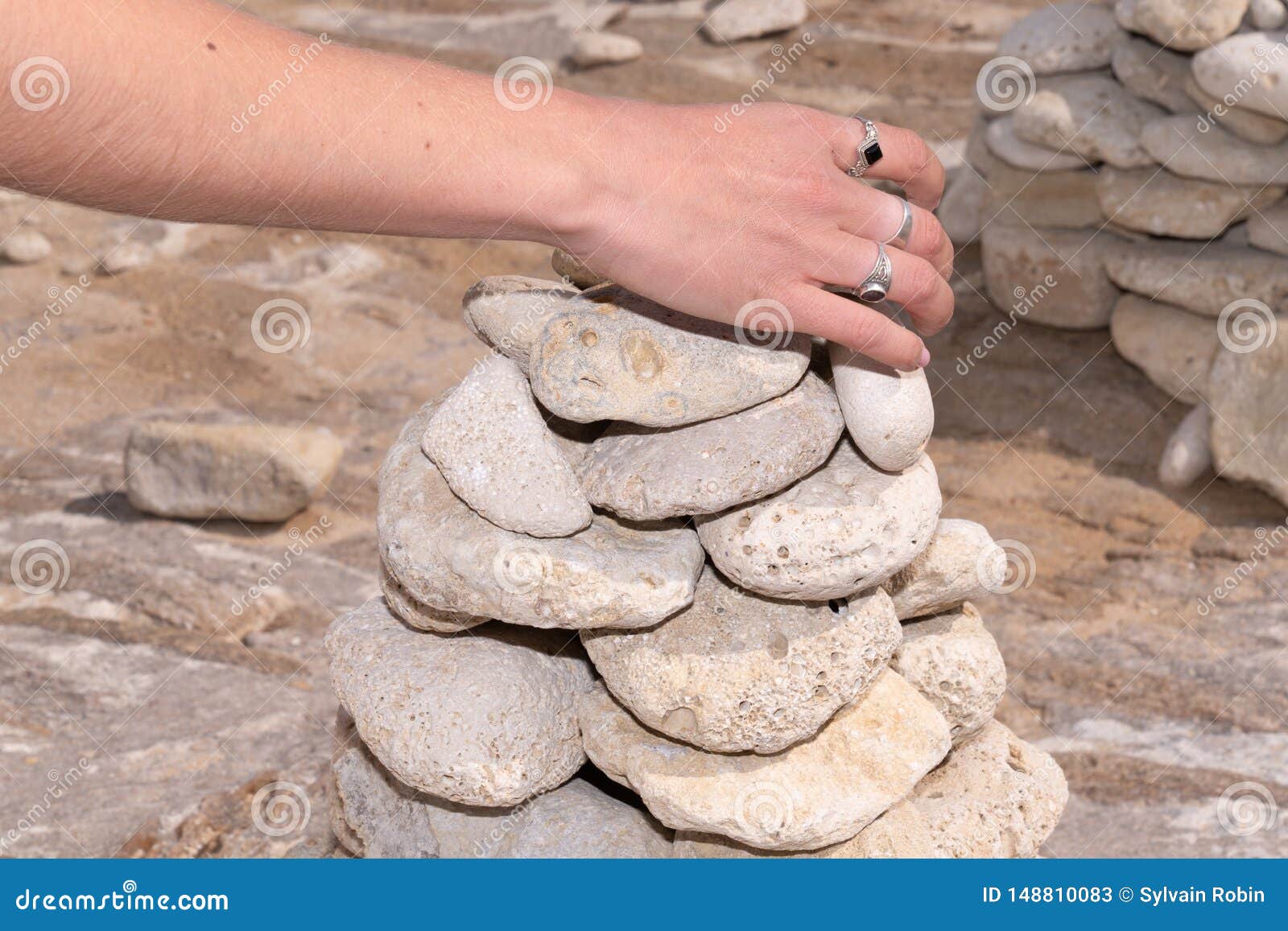 Human Hand Making Stack of Large Round Stones Near the Water Sea Beach ...