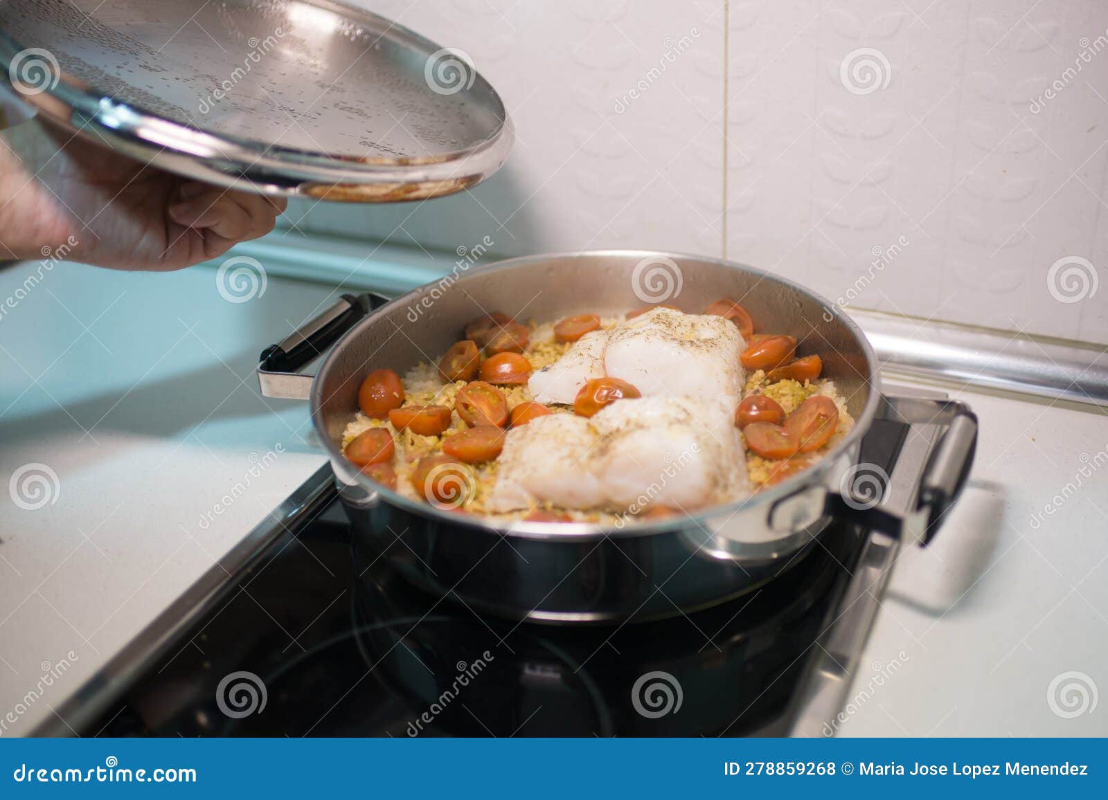 Human Hand Opening a Cooking Pot with Rice, Hake and Cherry Tomatoes ...