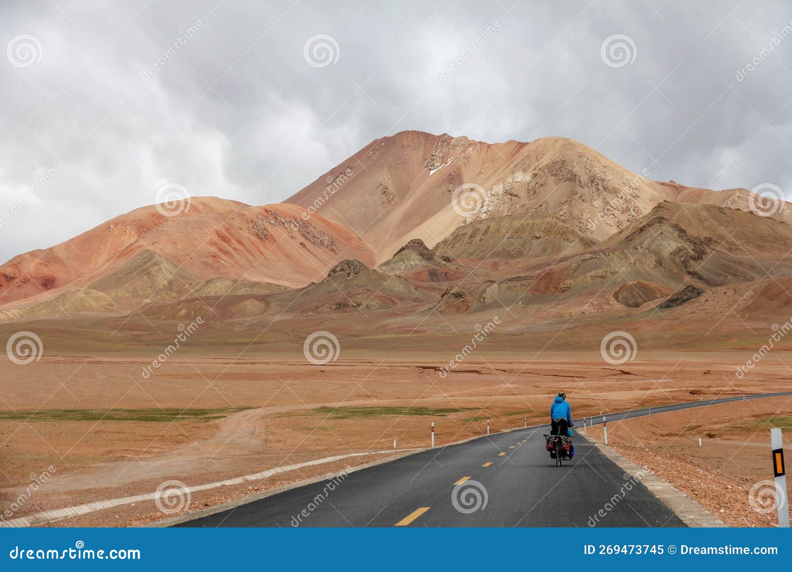 Human Riding Bicycle on Road through Desert Surrounded by Mountains ...