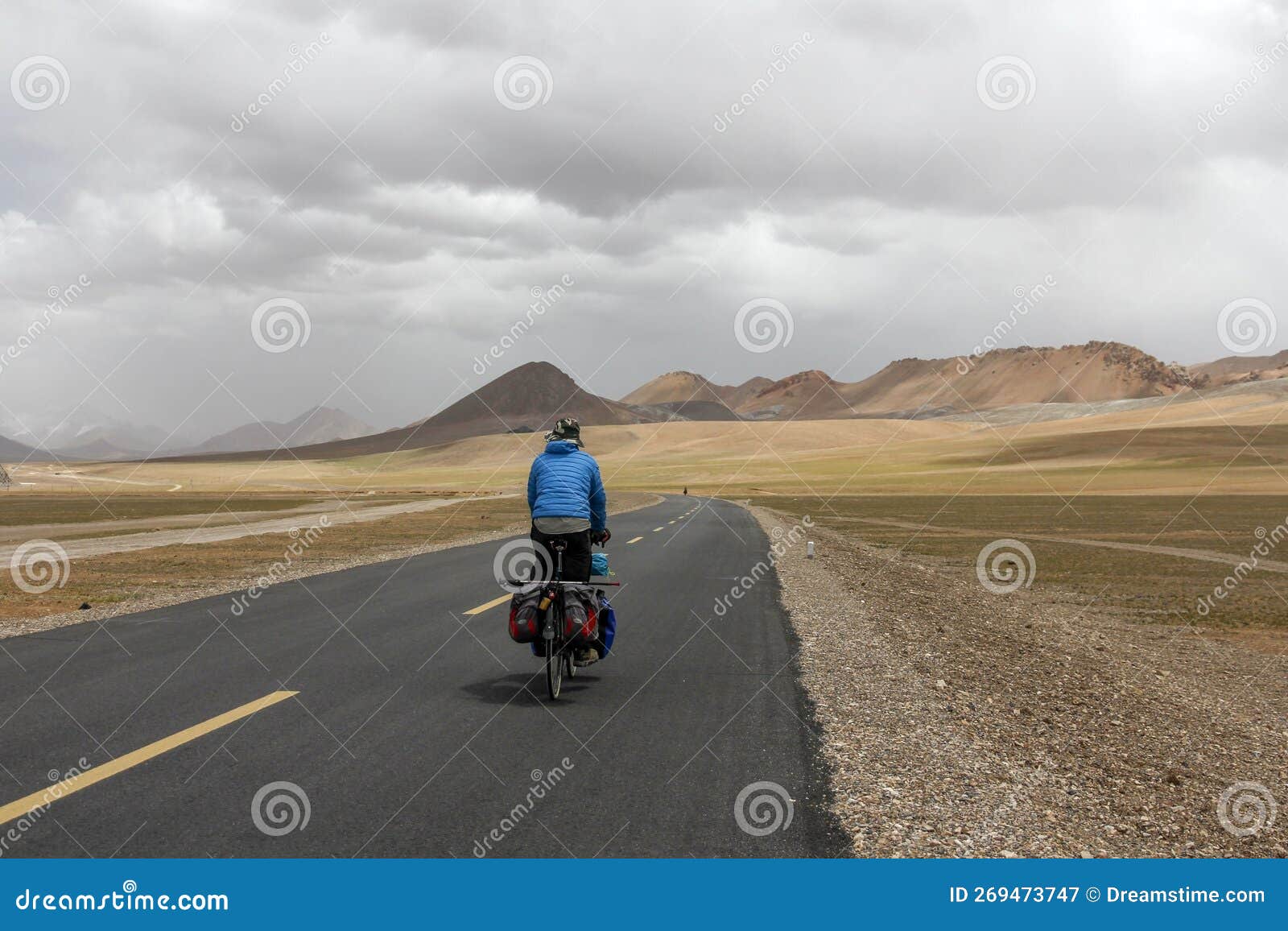 Human Riding Bicycle on Road through Desert Surrounded by Mountains ...