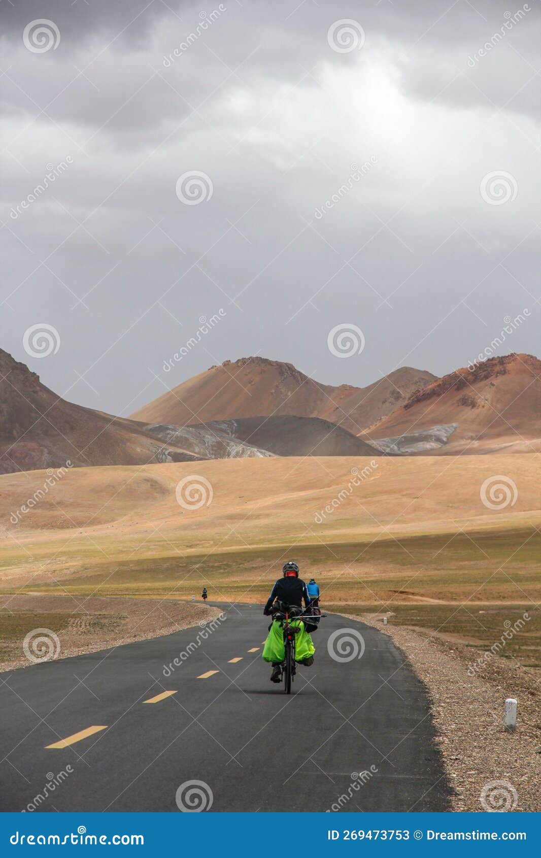 Human Riding Bicycle on Road through Desert Surrounded by Mountains ...