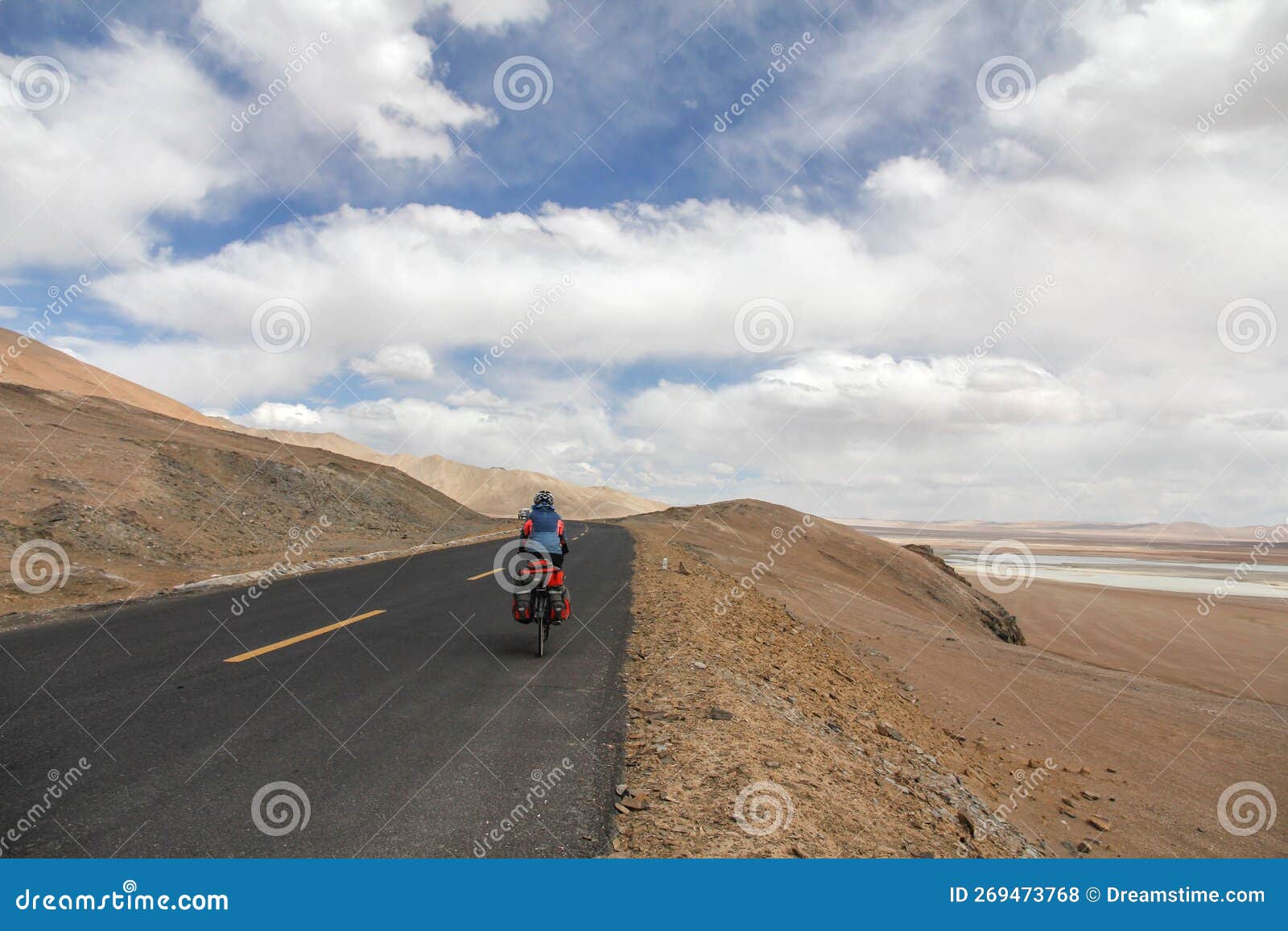 Human Riding Bicycle on Road through Desert Surrounded by Mountains ...