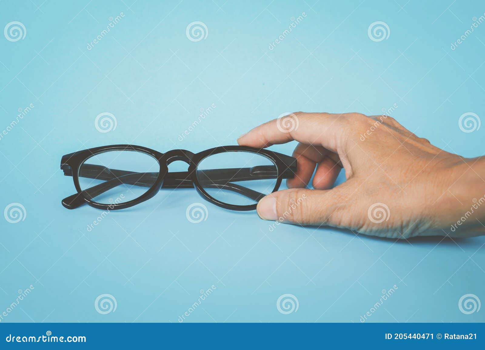 Human`s Hand Holding Eye Glasses on Blue Background Stock Image - Image ...