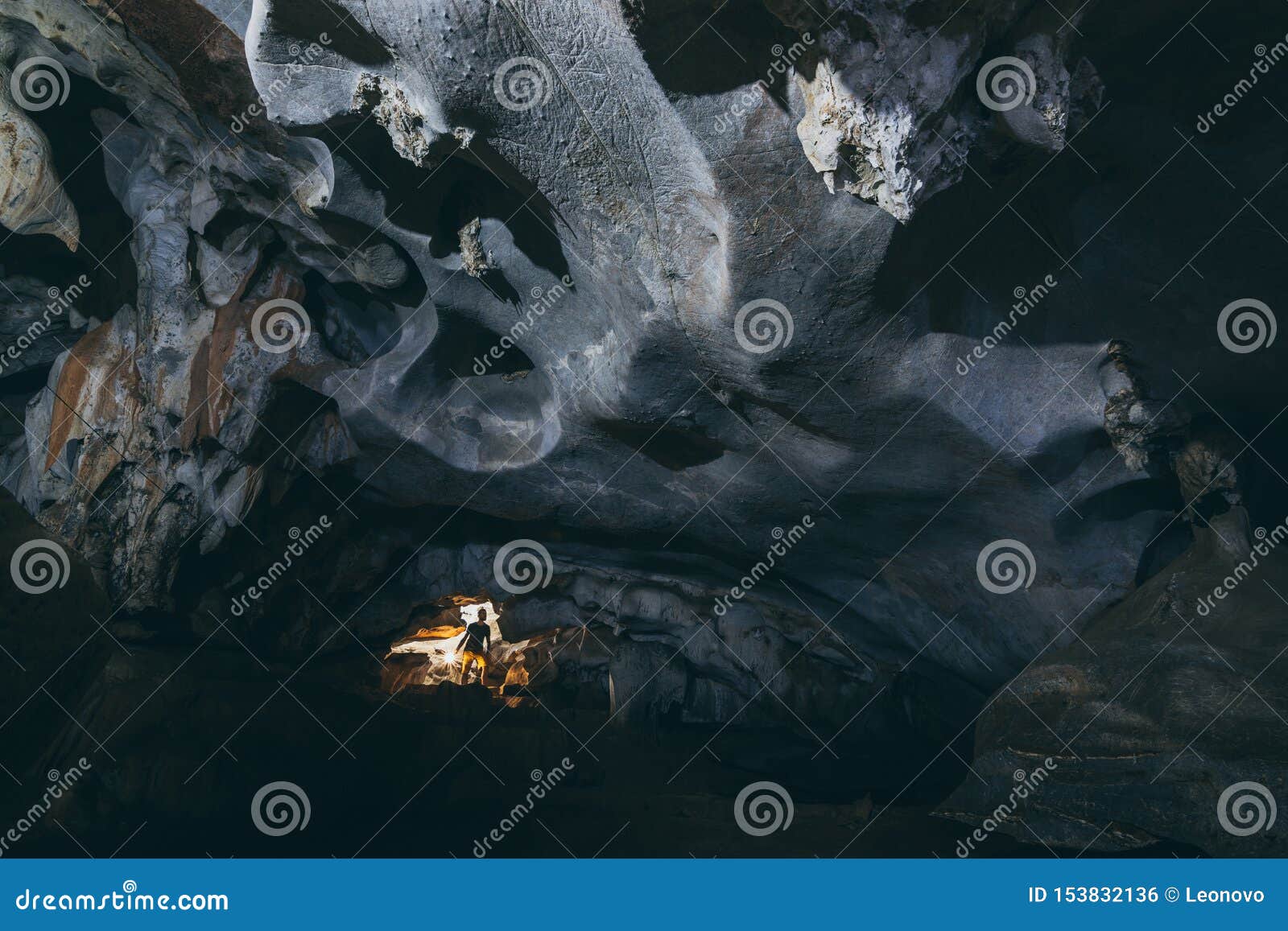 Human Silhouette Stands Inside The Cave With Light Coming From The ...