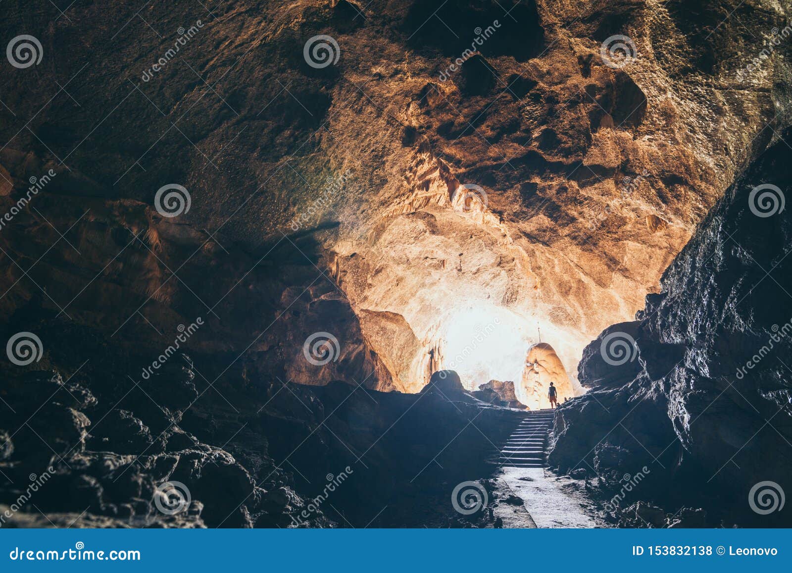 Human Silhouette Stands Inside the Cave with Light Coming from the ...
