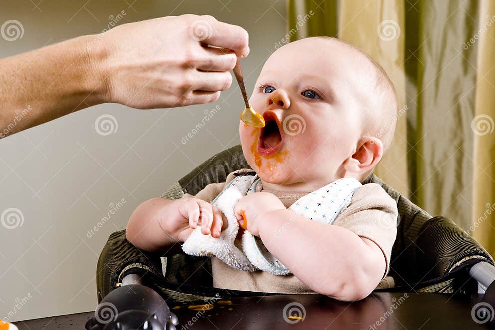 Hungry Baby Eating Solid Food from a Spoon Stock Photo - Image of table ...