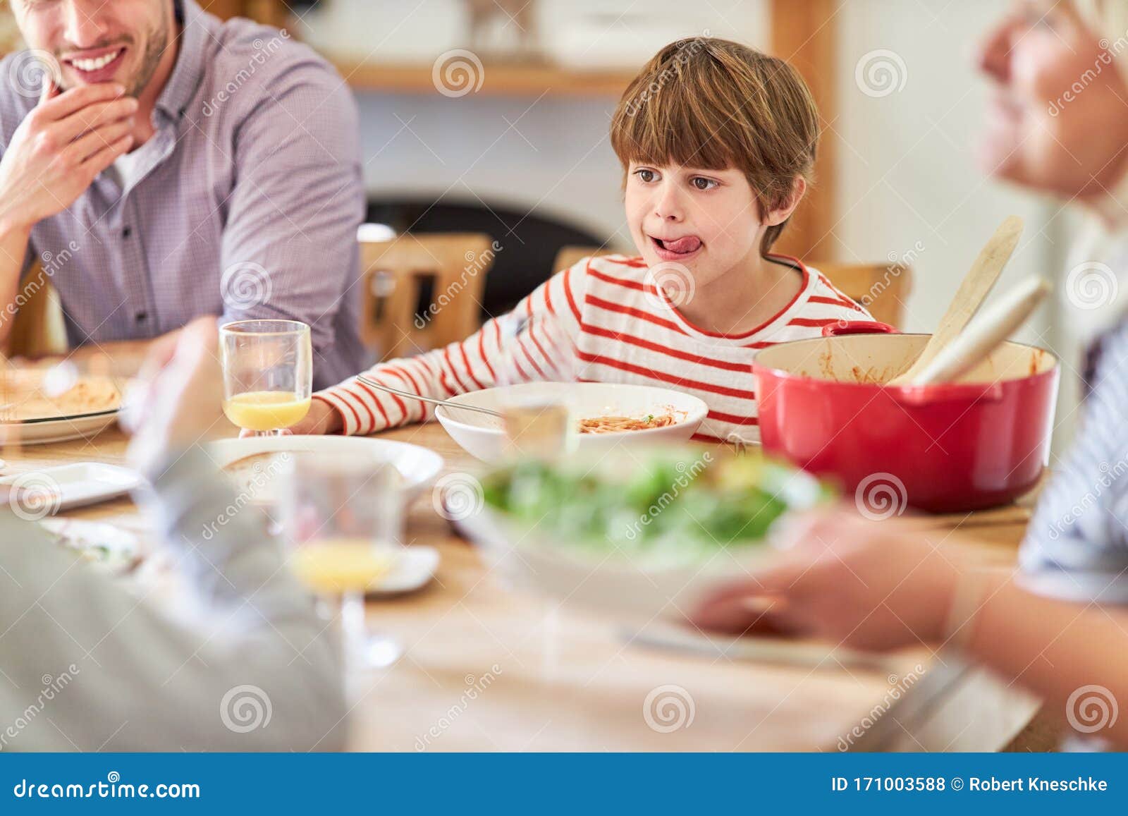Hungry Boy at the Dining Table with the Family Stock Photo - Image of ...