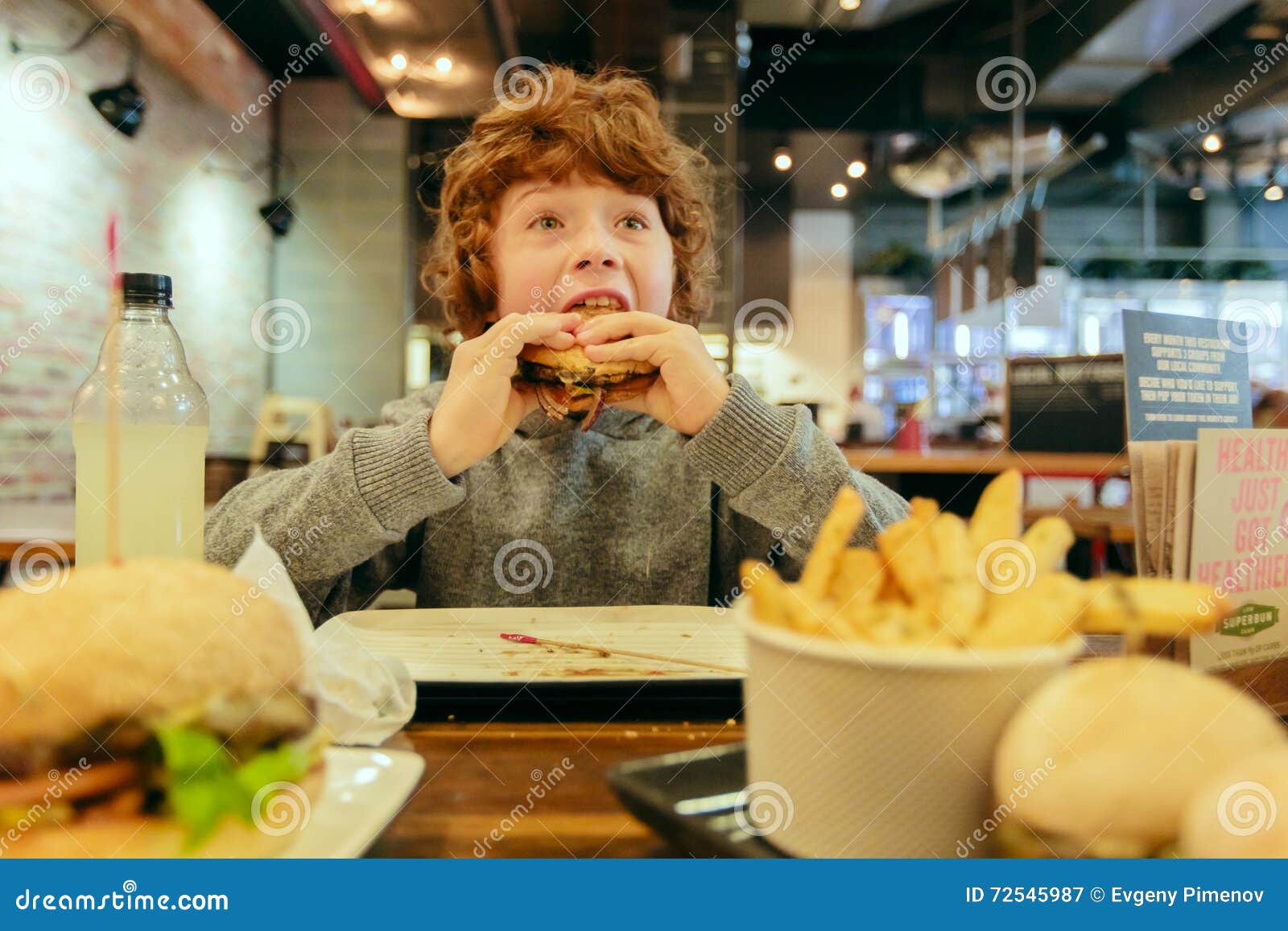 Hungry Boy Eats Burger in Restaurant Stock Image - Image of fastfood ...