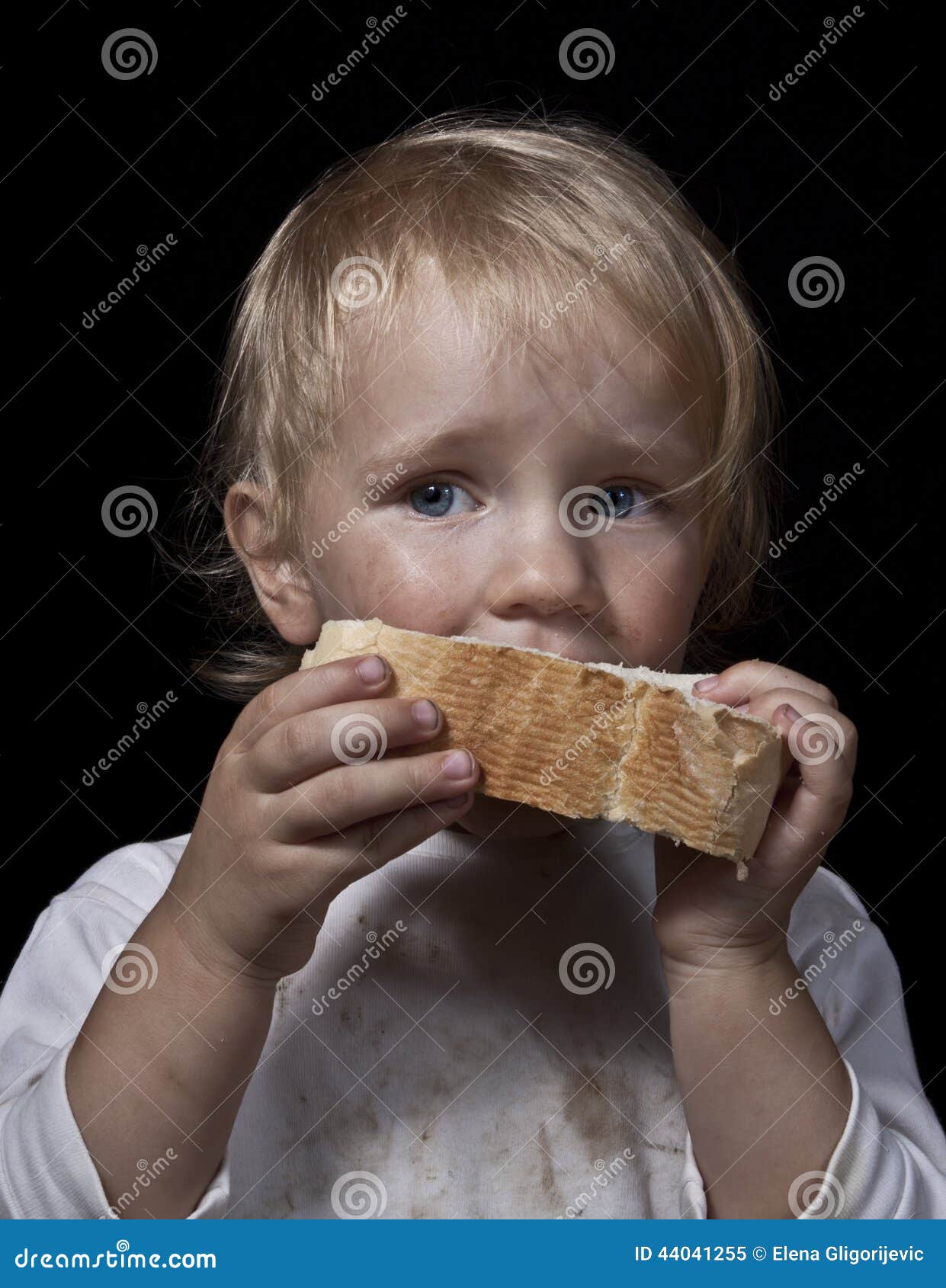 Hungry child eating bread stock image. Image of emotions - 44041255