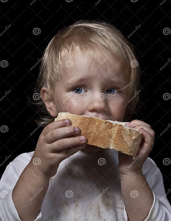 Hungry child eating bread stock image. Image of emotions - 44041255