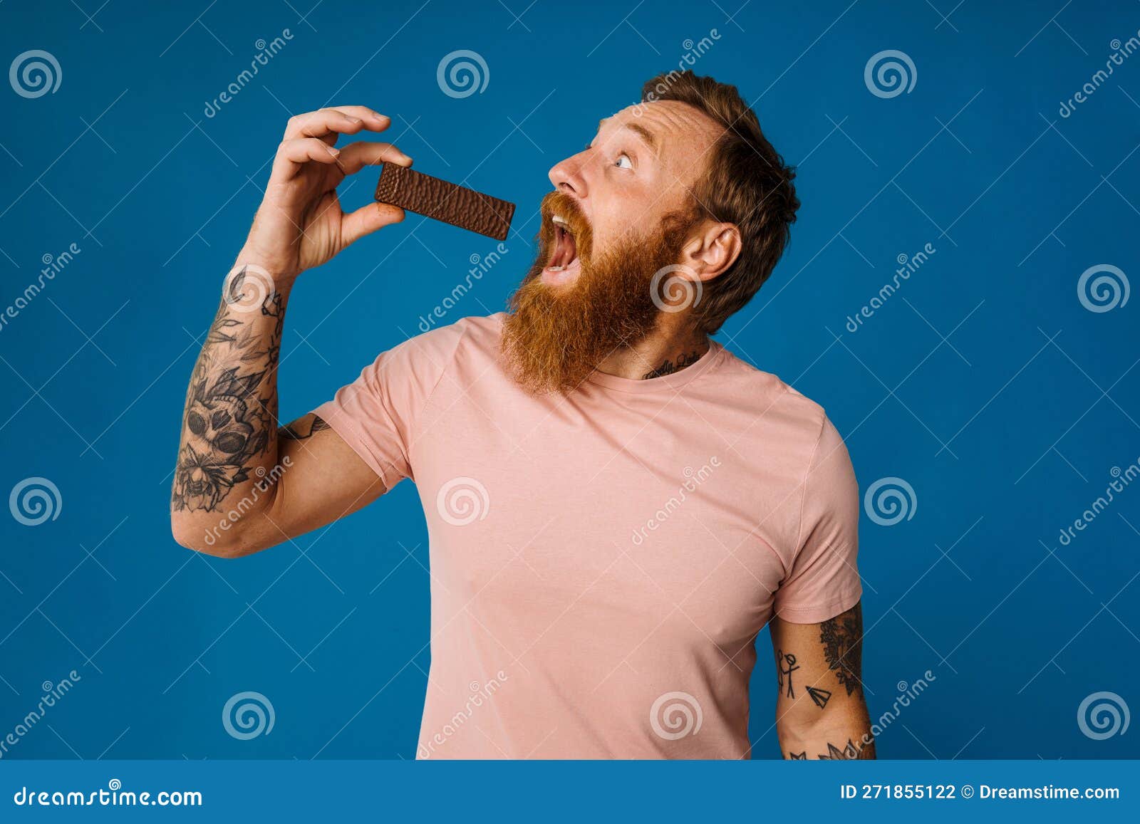 Hungry Man Eating Candy Bar Isolated Over Blue Background Stock Photo ...