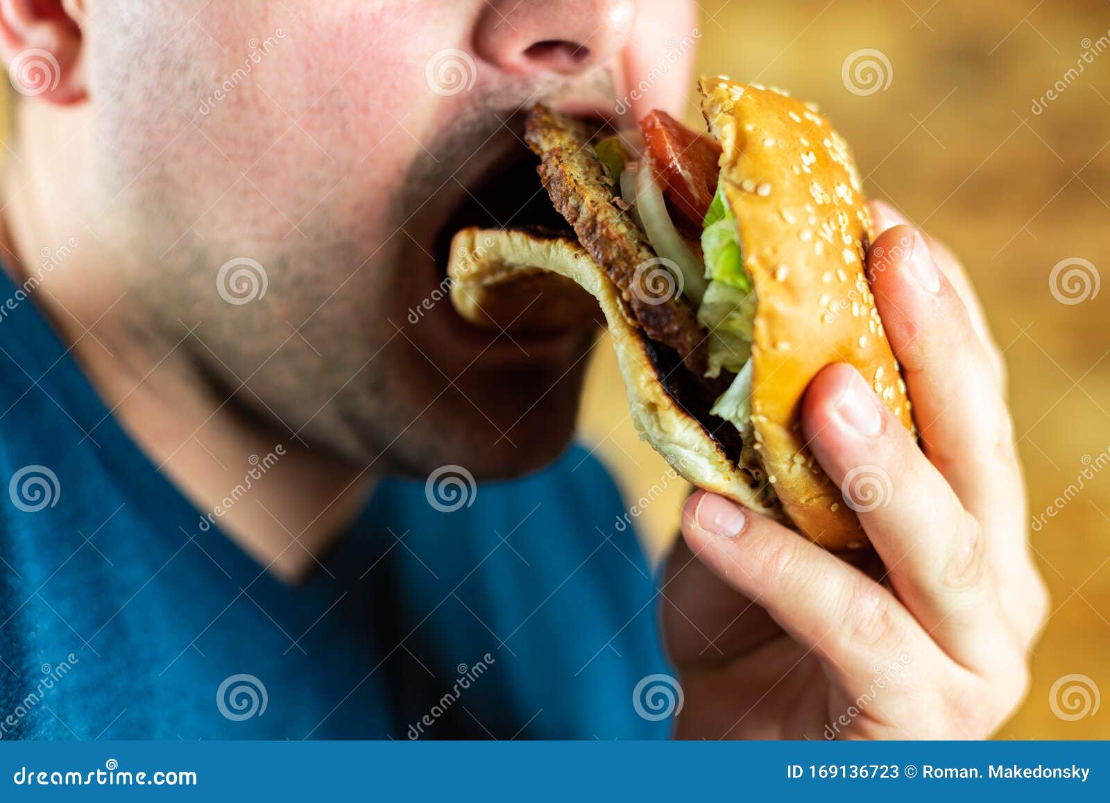 The Hungry Young Man Aggressively Eats a Burger. Fast Food Stock Image ...