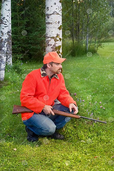 Hunter crouching stock image. Image of jacket, orange - 7112337