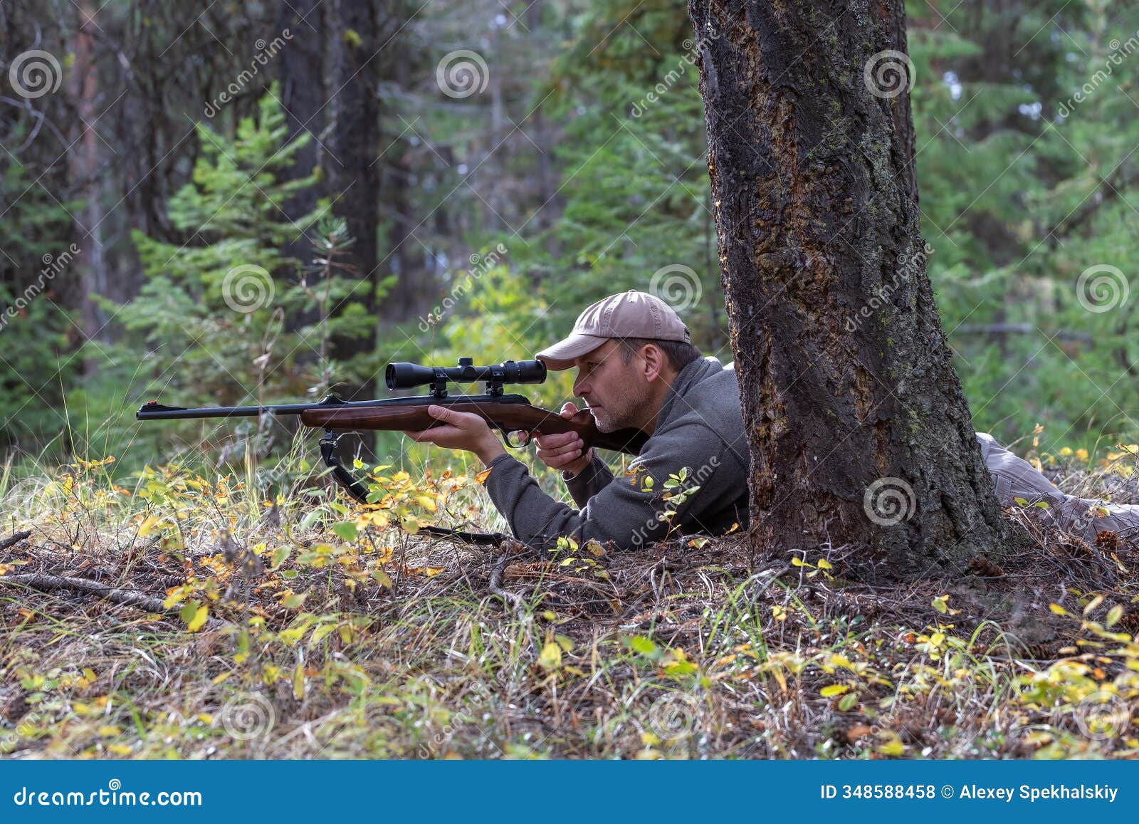 Hunter with Rifle Lies Behind Tree on the Ground. Stock Photo - Image ...