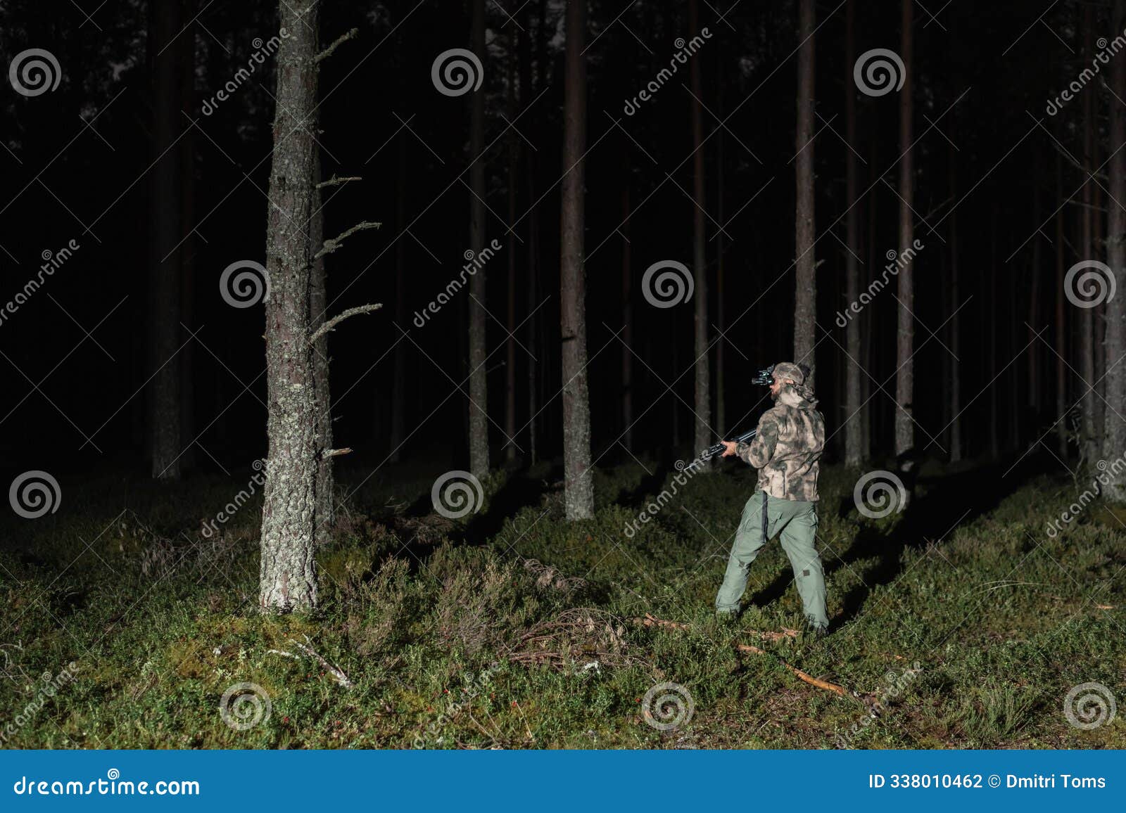 A Hunter with a Night Vision Device and Rifle in a Dark Forest. Night ...