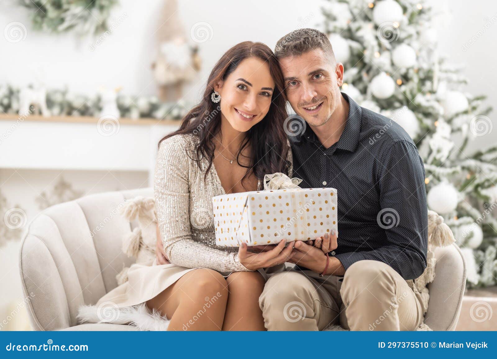 Husband and Wife Enjoy Christmas Togetherness Holding a Present in ...