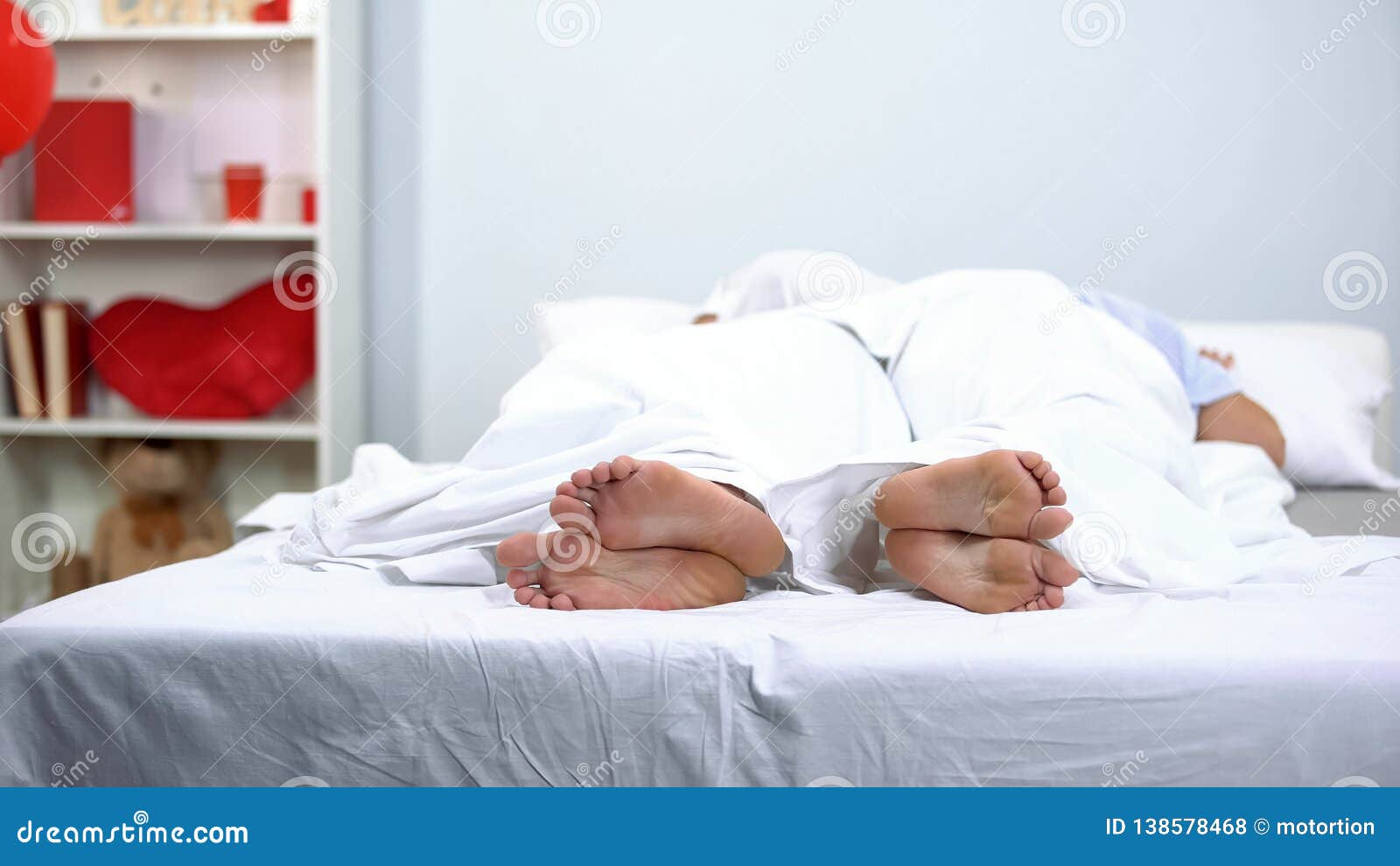 Husband And Wife Sleeping In Bed Healthy Feet Seen Under Blanket